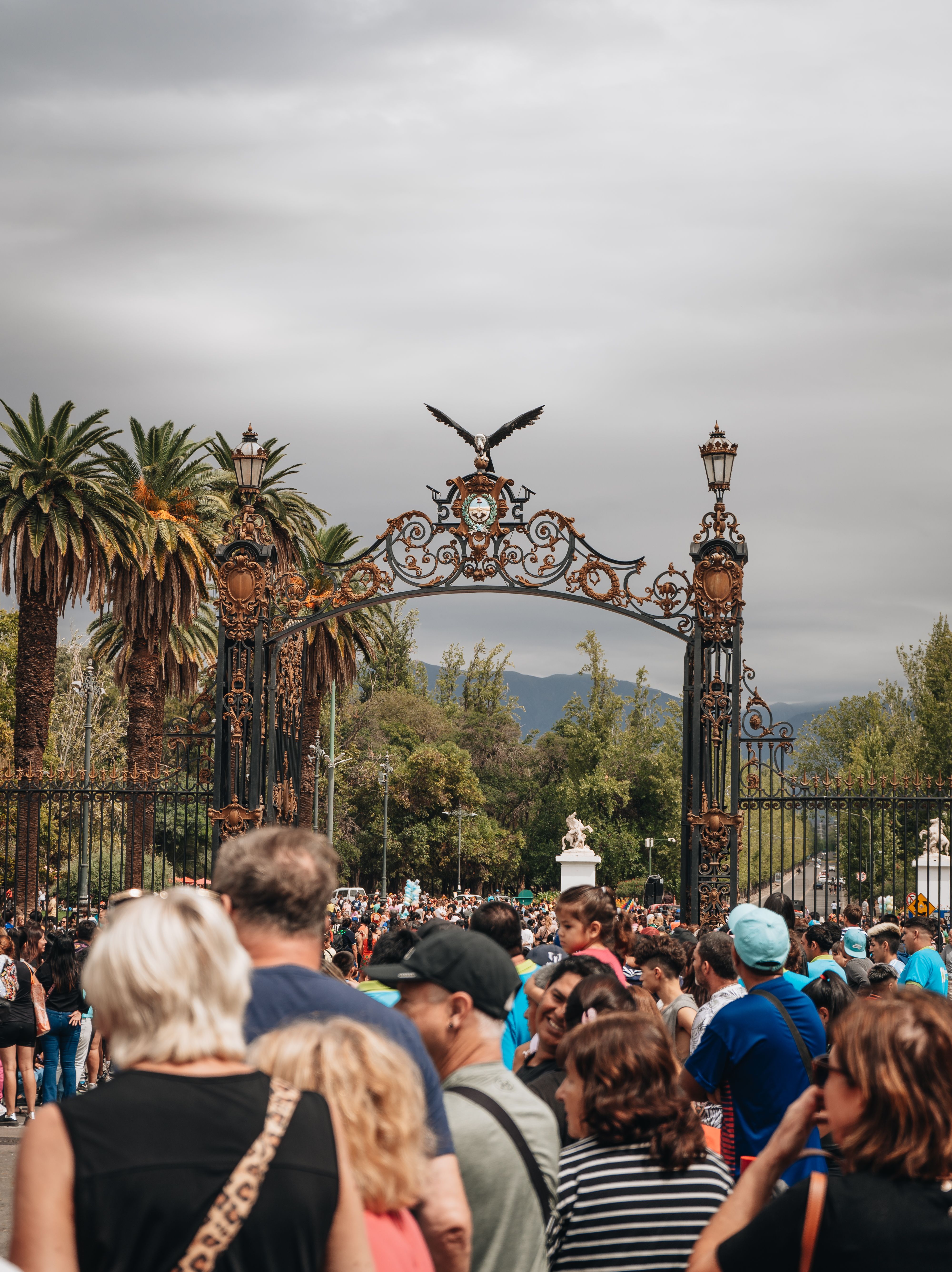 A crowd of people standing in front of an ornate gate · Free Stock Photo