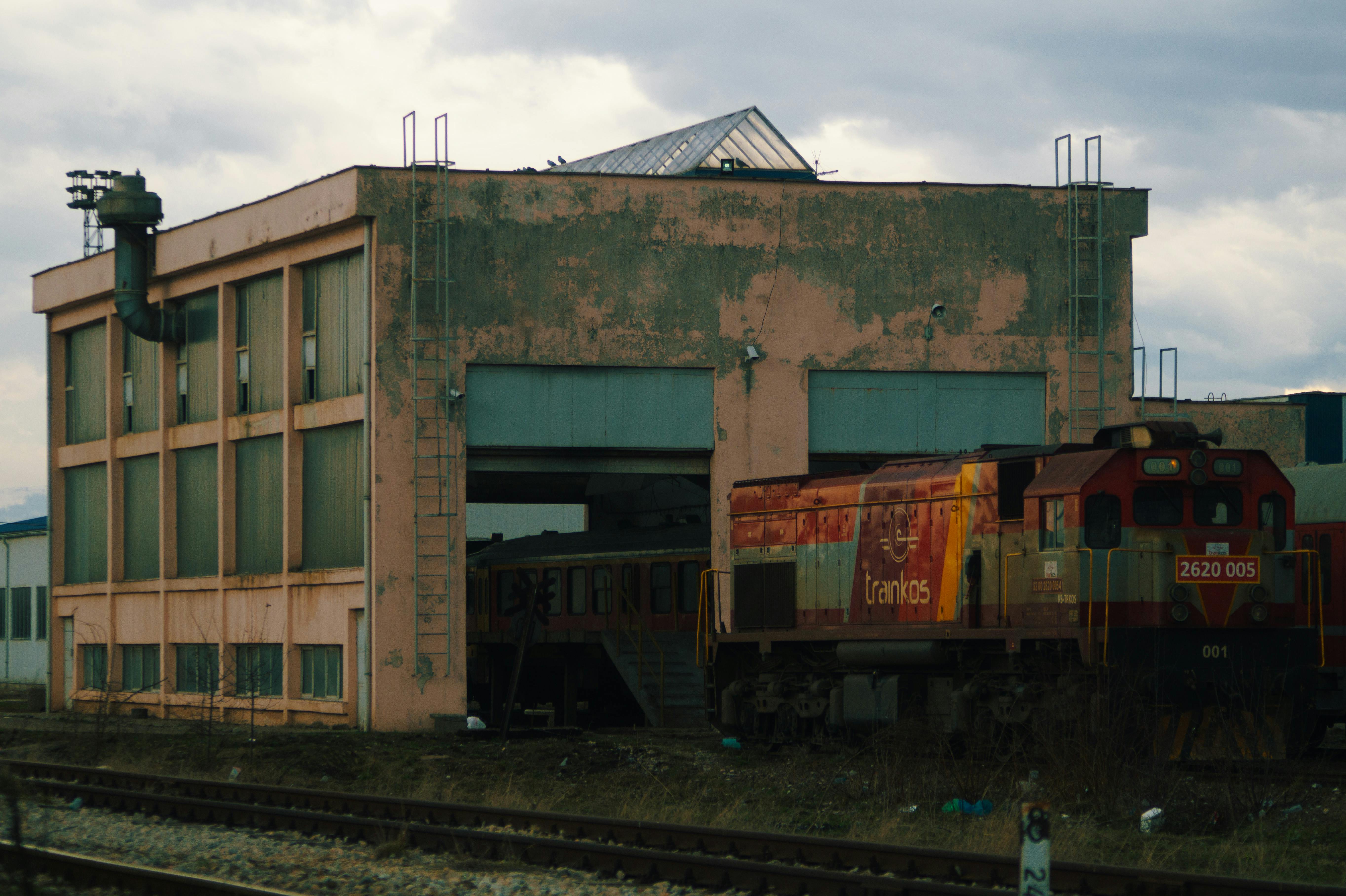 A Locomotive and a Train Standing near an Abandoned Building · Free ...
