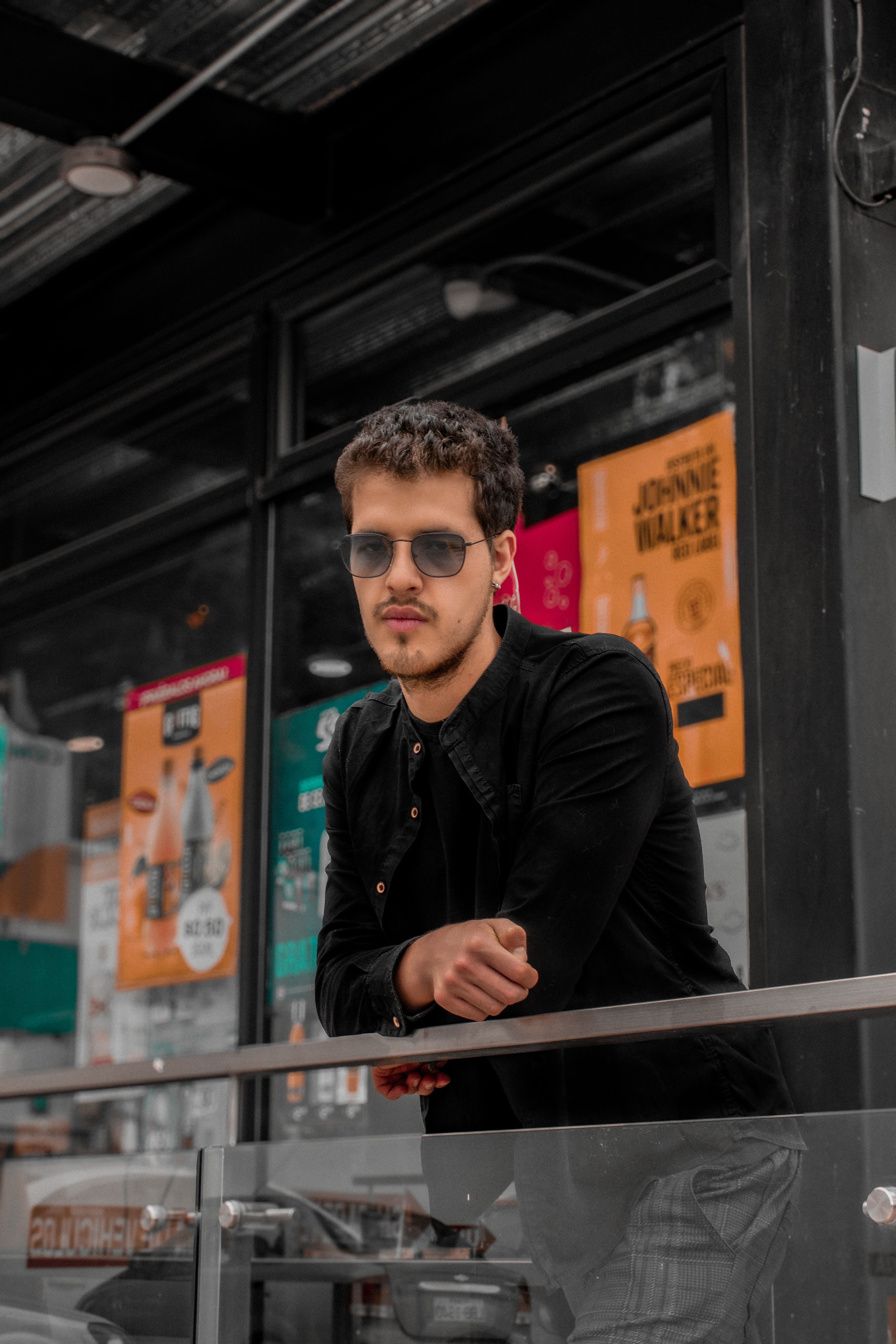 Photo of a Man Leaning against a Balustrade by a Bar · Free Stock Photo