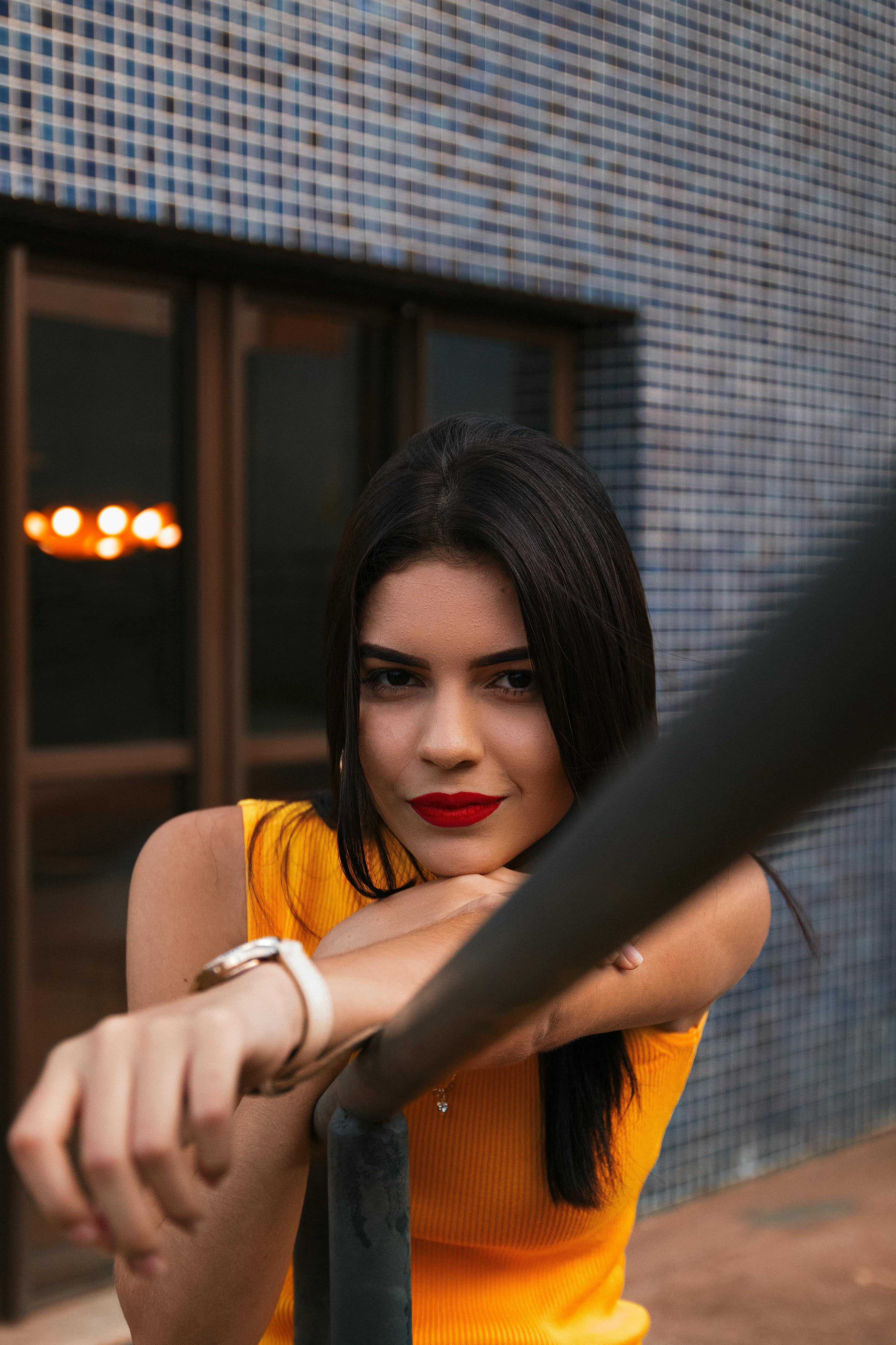 Woman Wearing Yellow Tank Top Leaning on Railing · Free Stock Photo