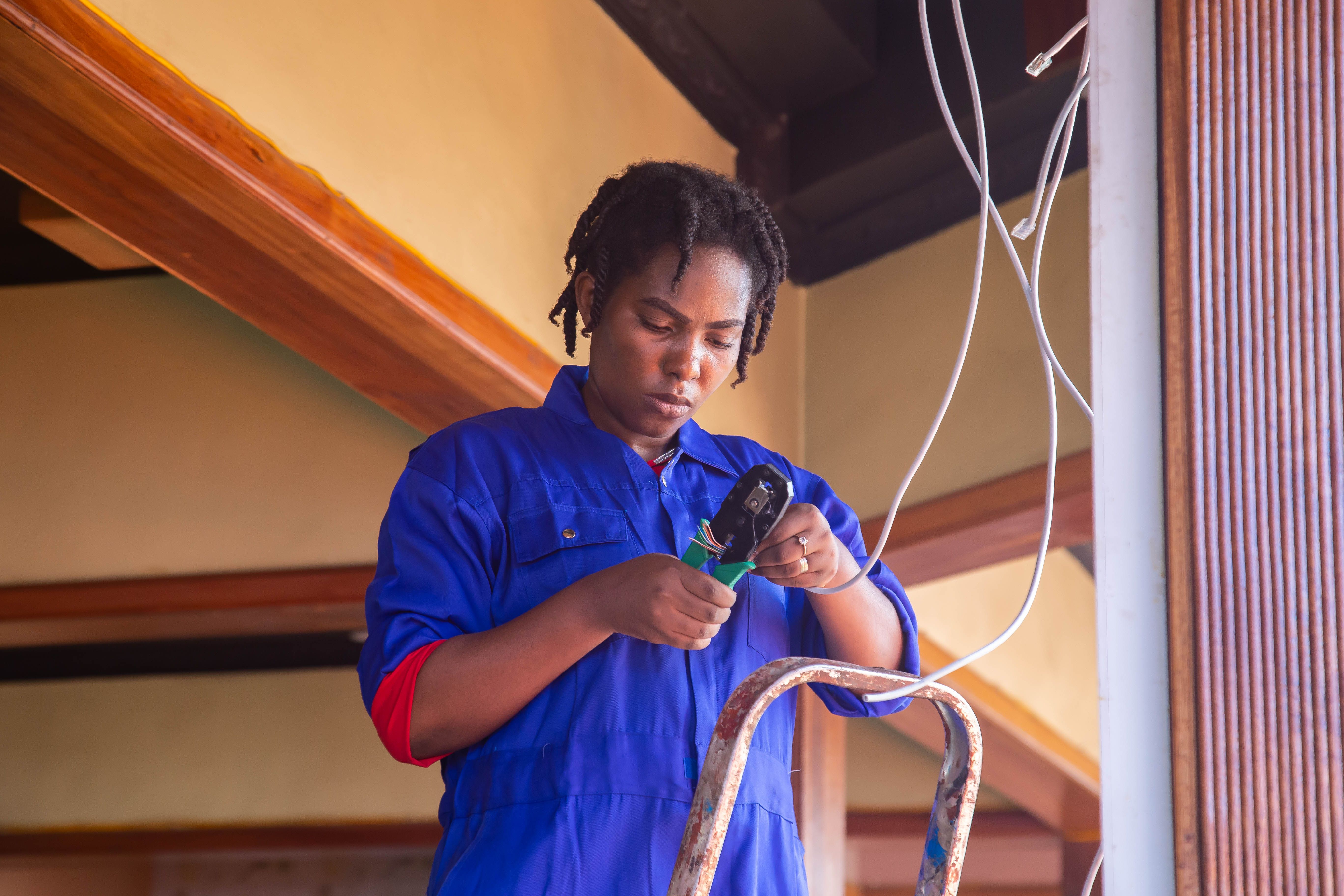 A Female Electrician Standing on a Ladder and Holding Cables · Free ...