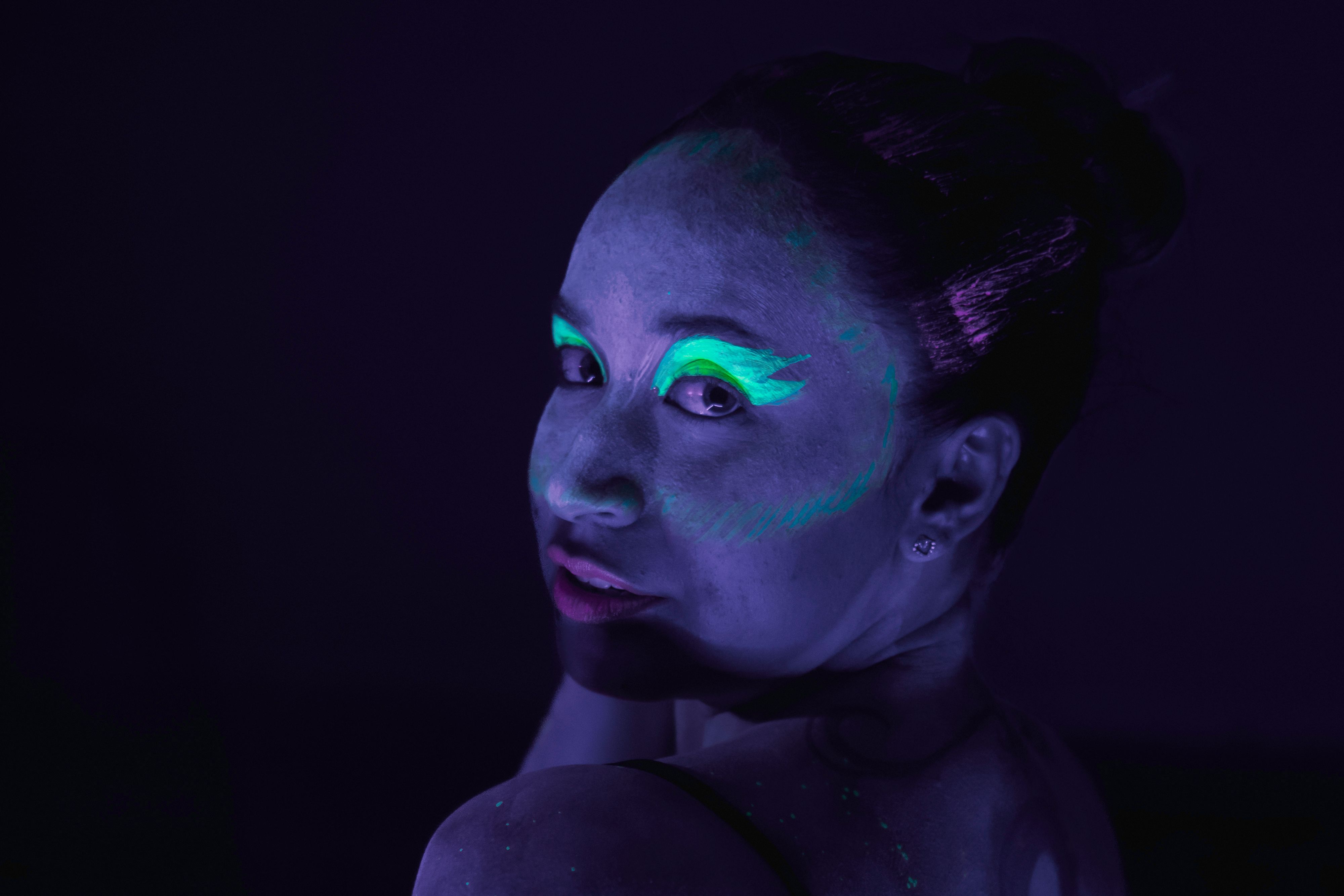 Photo of a Woman Wearing Glowing Makeup under UV Lights · Free Stock Photo