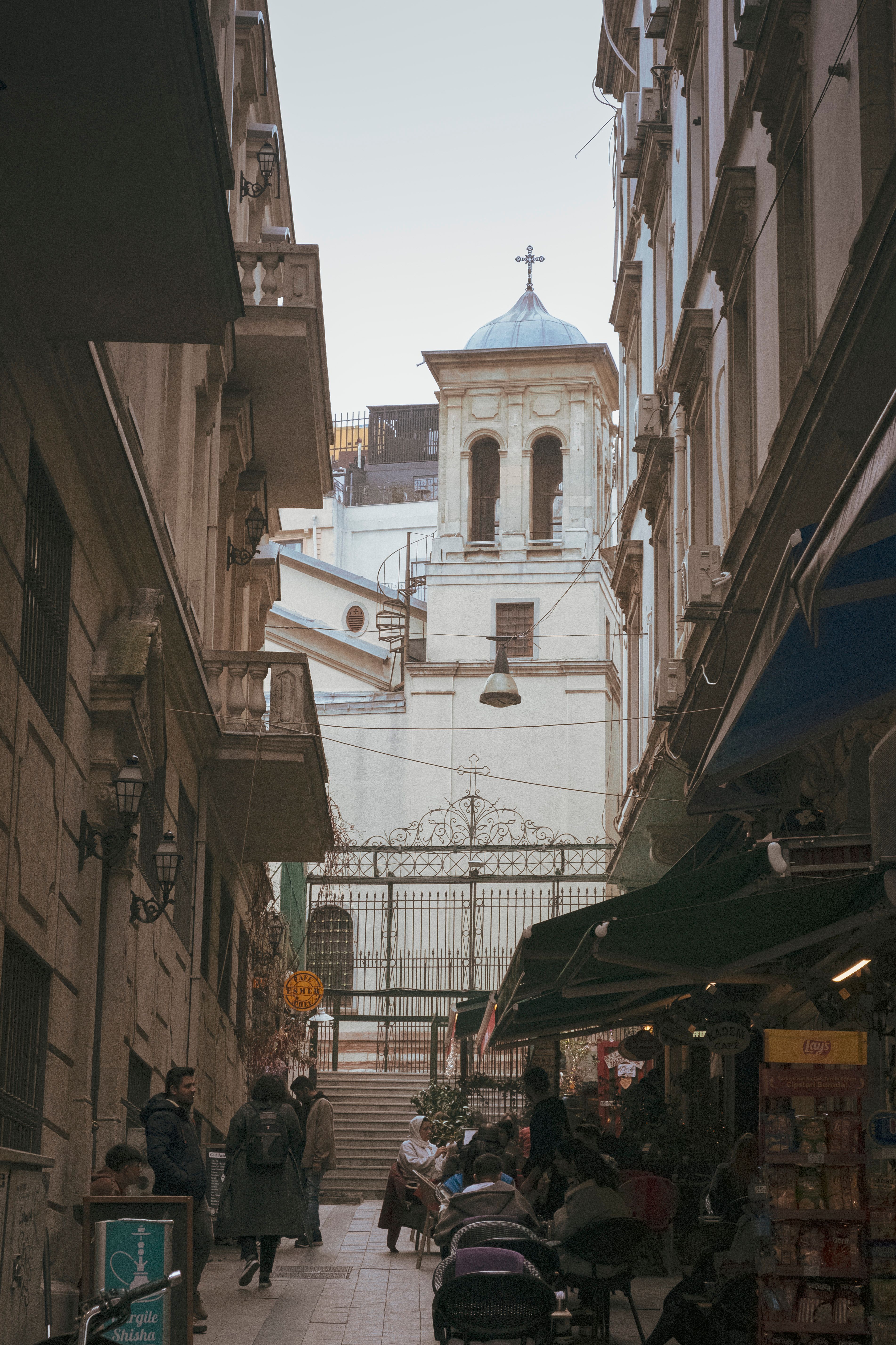 A narrow street with people walking down it · Free Stock Photo