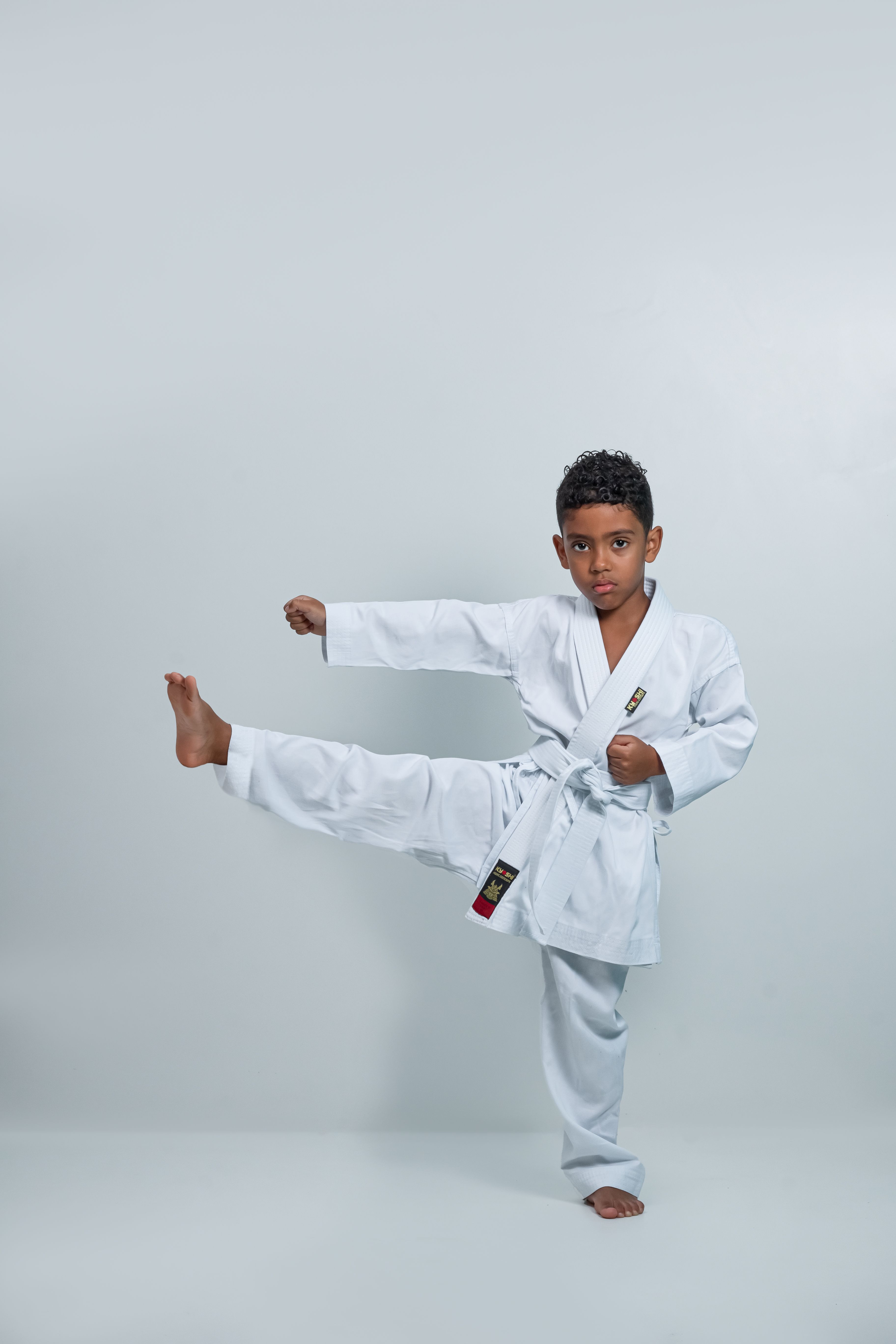 Boy Standing with Leg Raised in Karate Kimono · Free Stock Photo