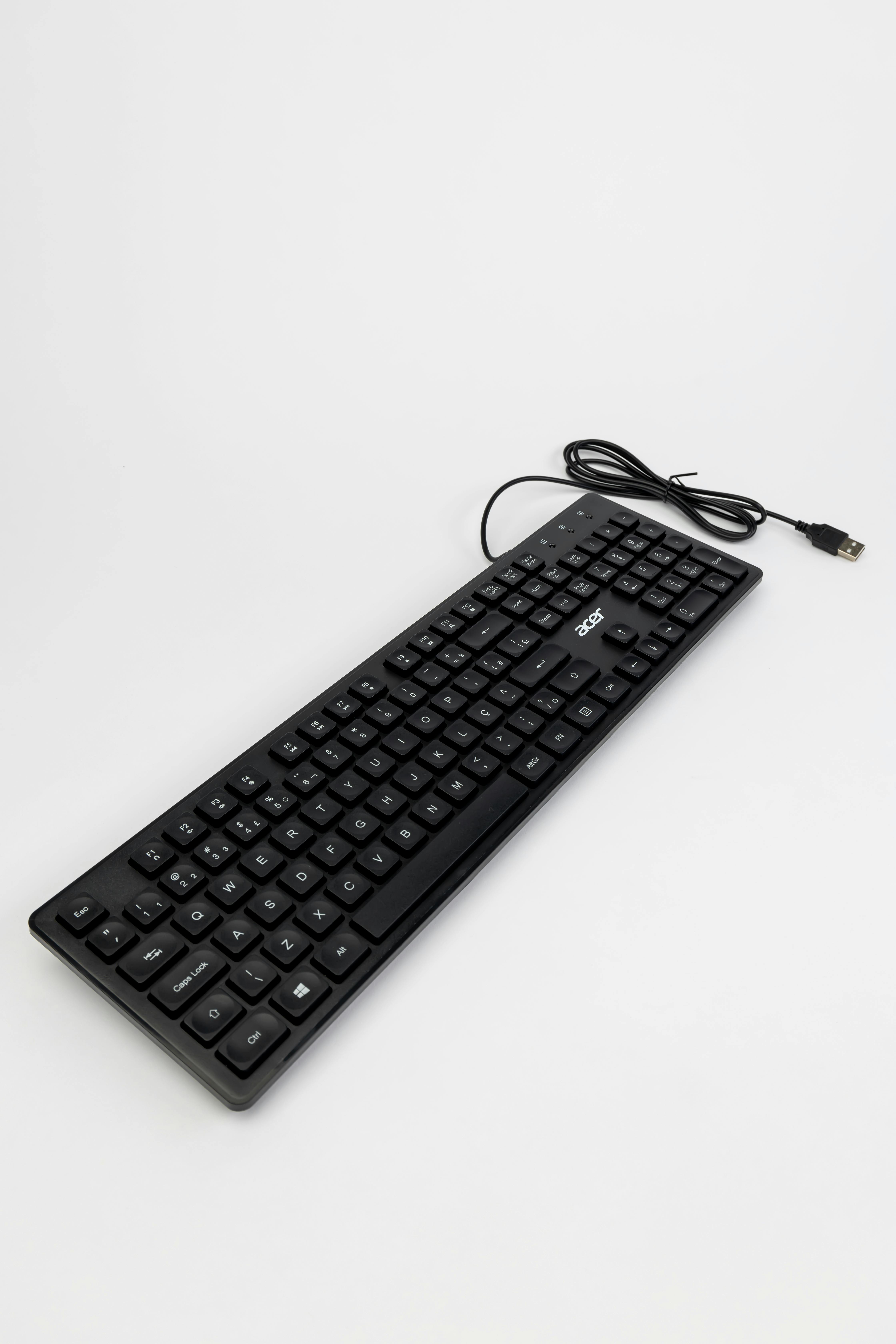 Computer Keyboard with a Cable on a Plain Background · Free Stock Photo