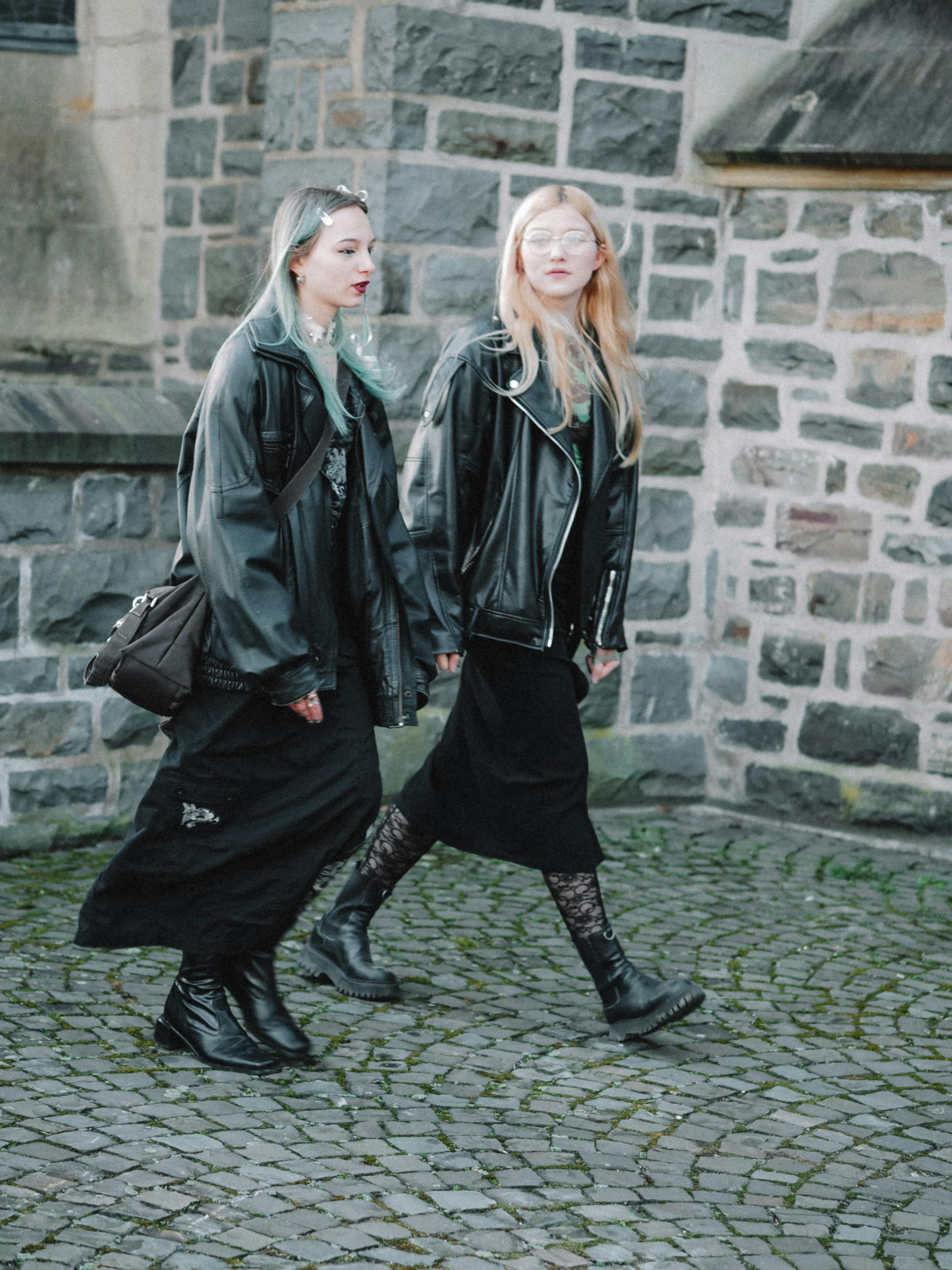 Friends in Leather Jackets and Boots Walking Along the Cobblestone ...
