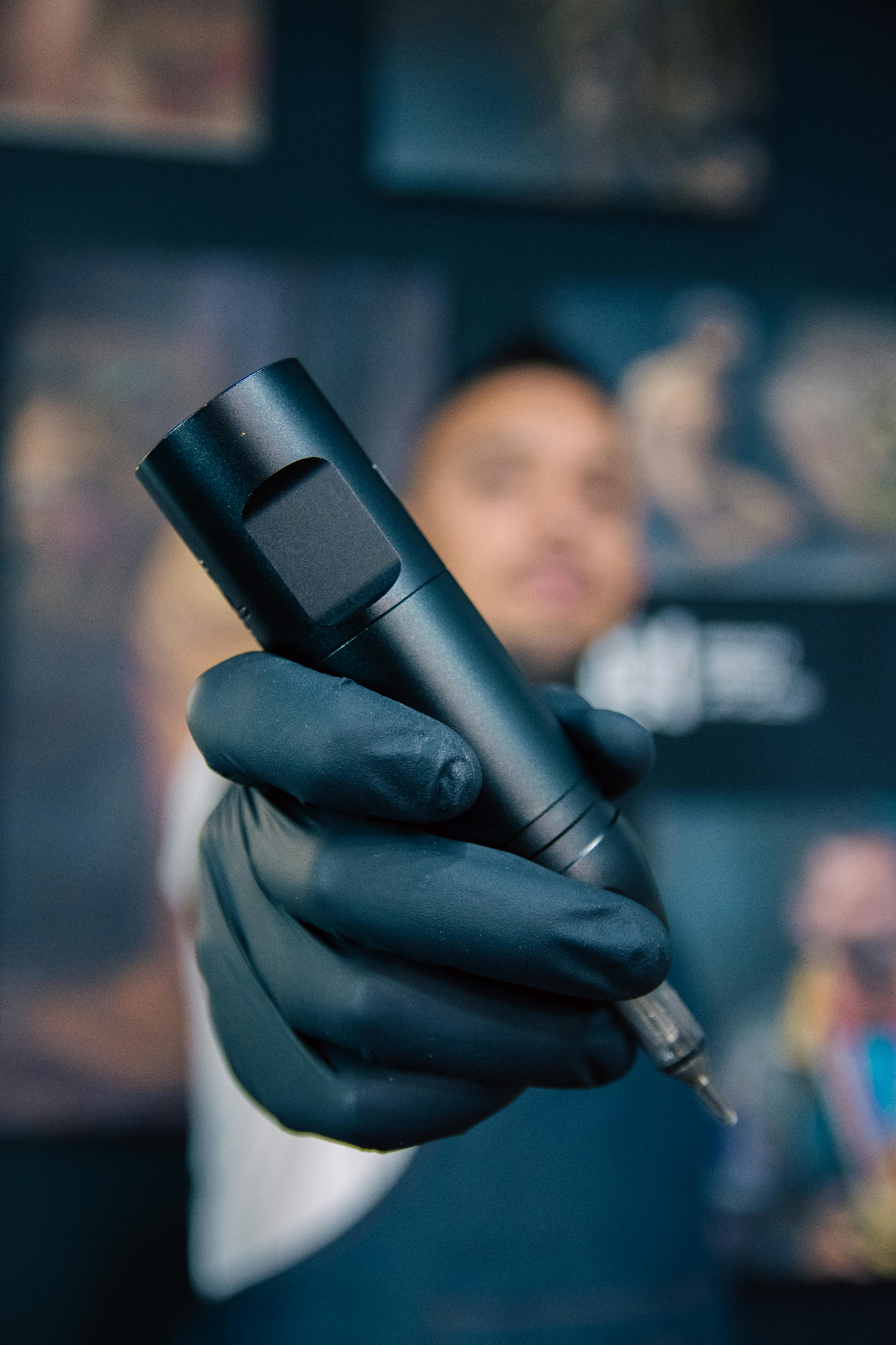 Closeup of a Tattooing Tool in a Hand Wearing a Black Rubber Glove ...