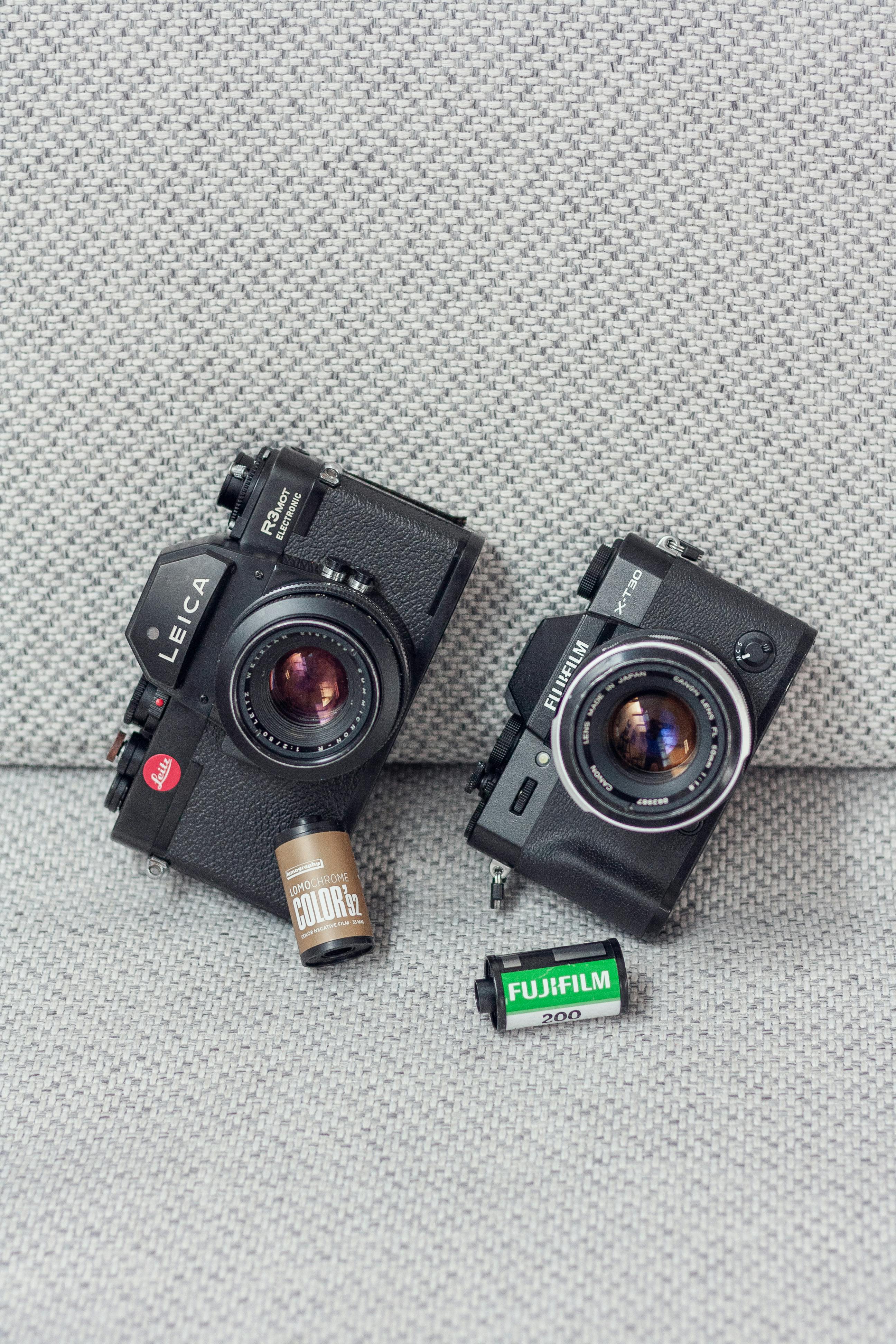 Two cameras with batteries and a battery charger · Free Stock Photo
