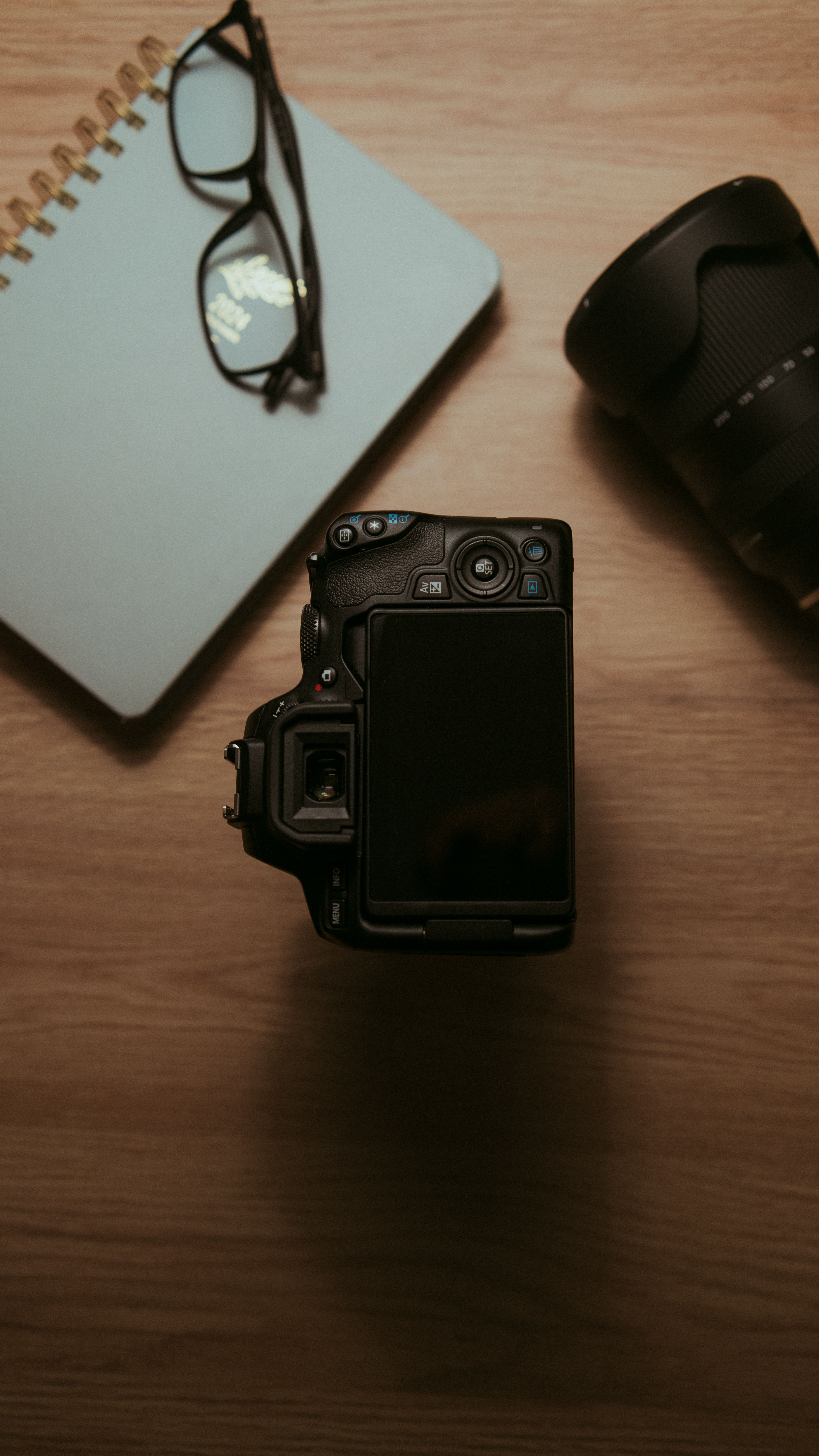 Digital Camera, Eyeglasses and Notebook on Table · Free Stock Photo