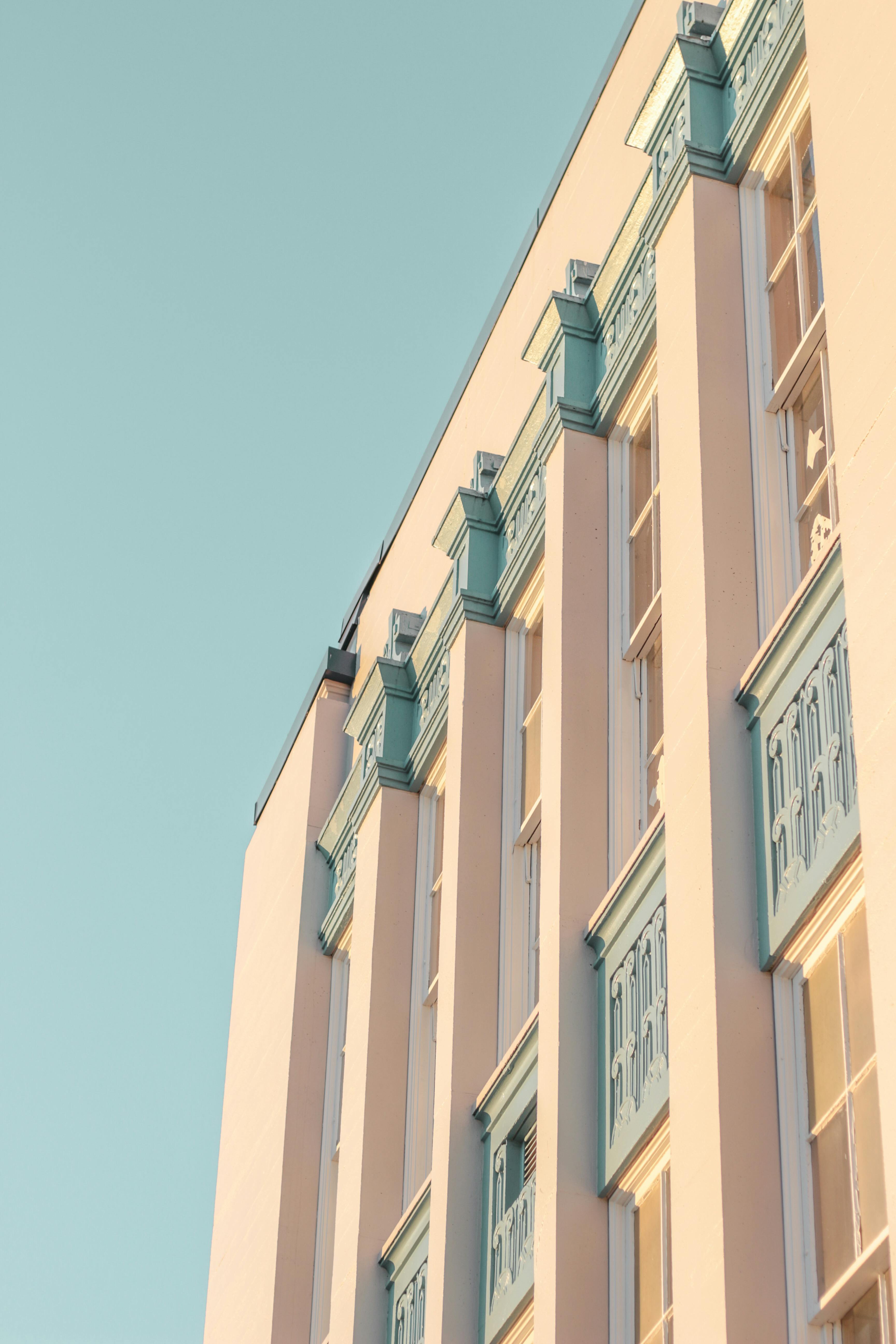 Facade of Pastel Neoclassical Building against Clear Sky · Free Stock Photo