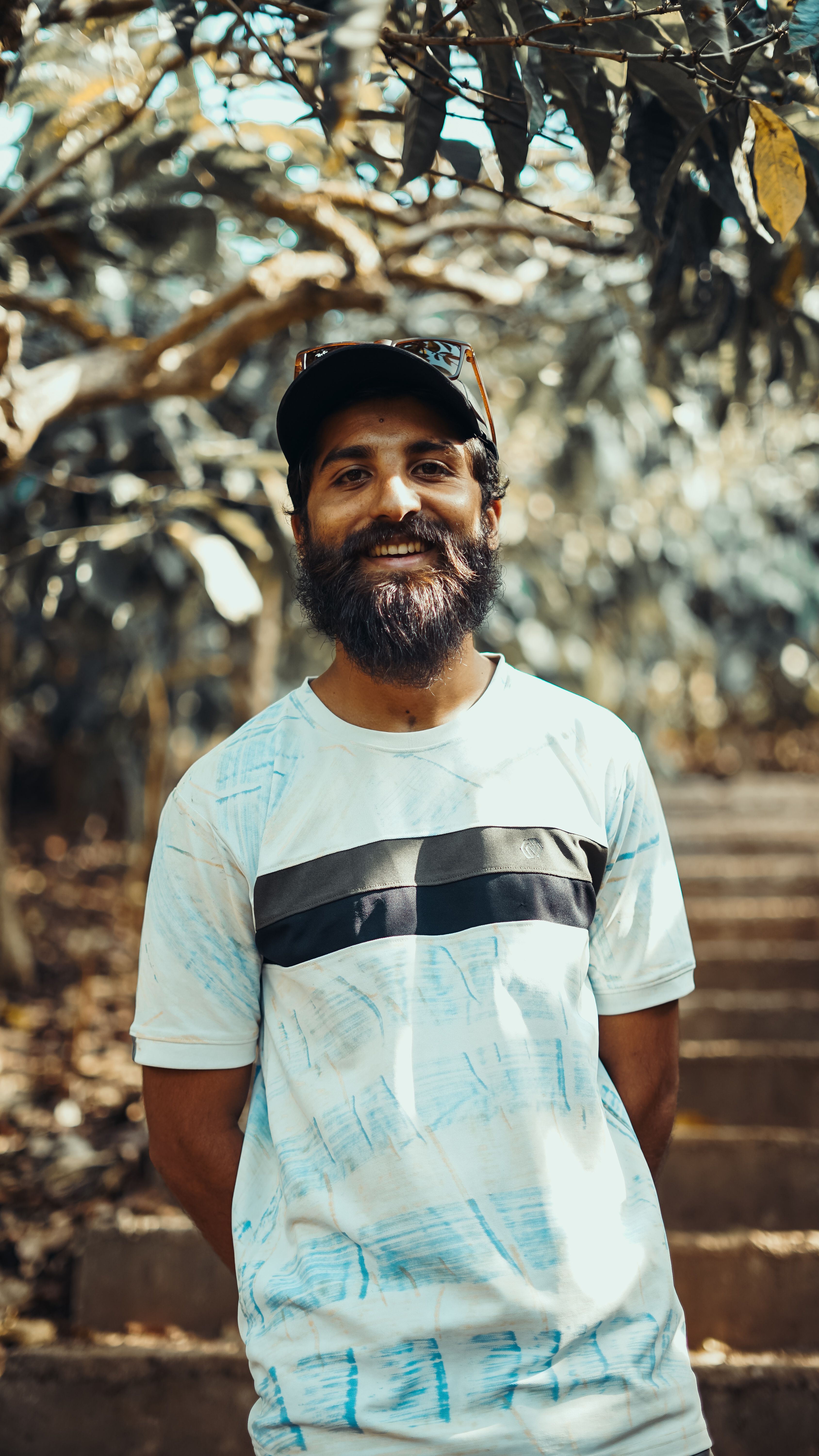 Smiling Bearded Man Standing under Tree in Park · Free Stock Photo