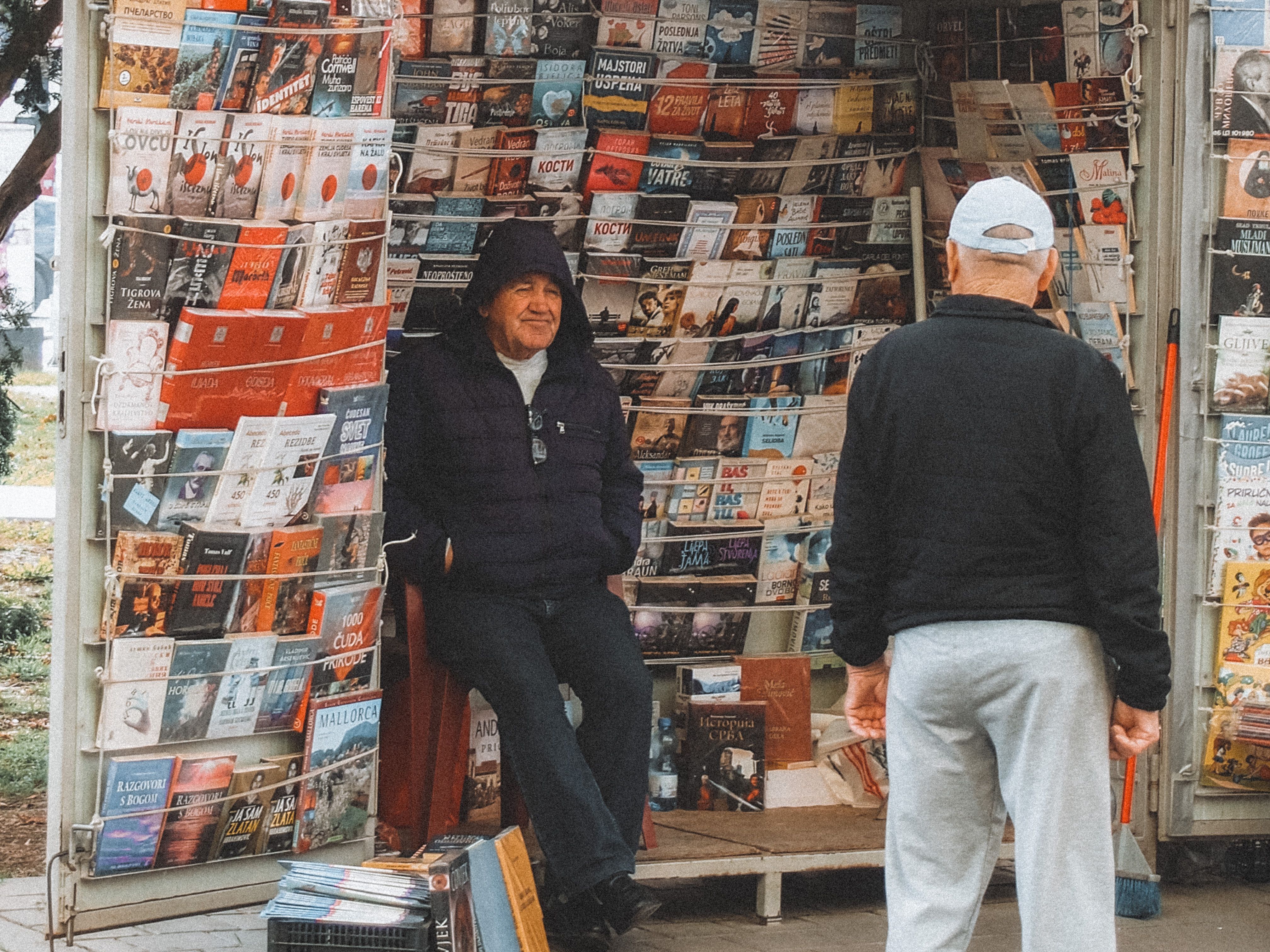 Film Photo of a Man Selling Magazines on a Street · Free Stock Photo