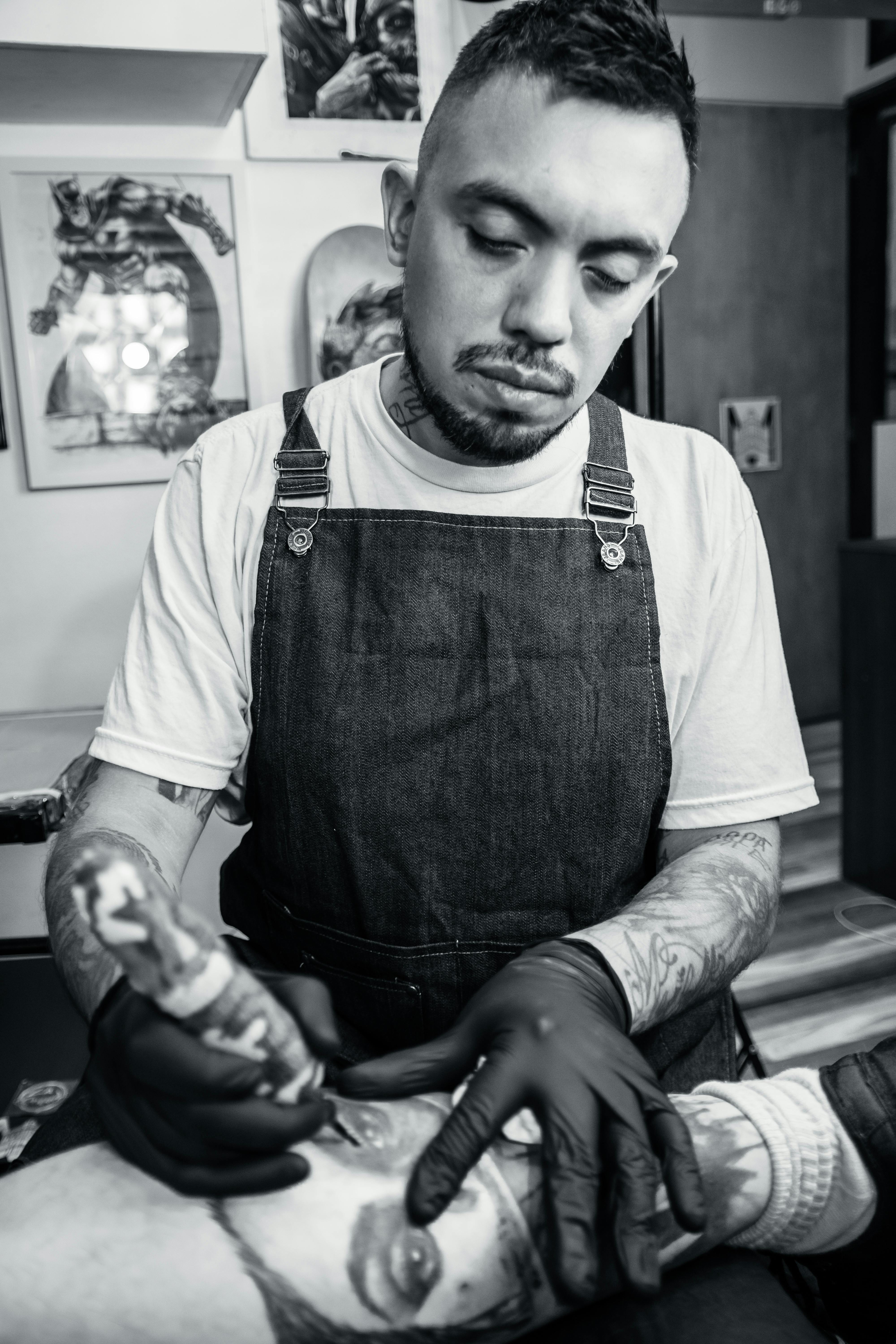 Black and White Photograph of a Man Tattooing · Free Stock Photo