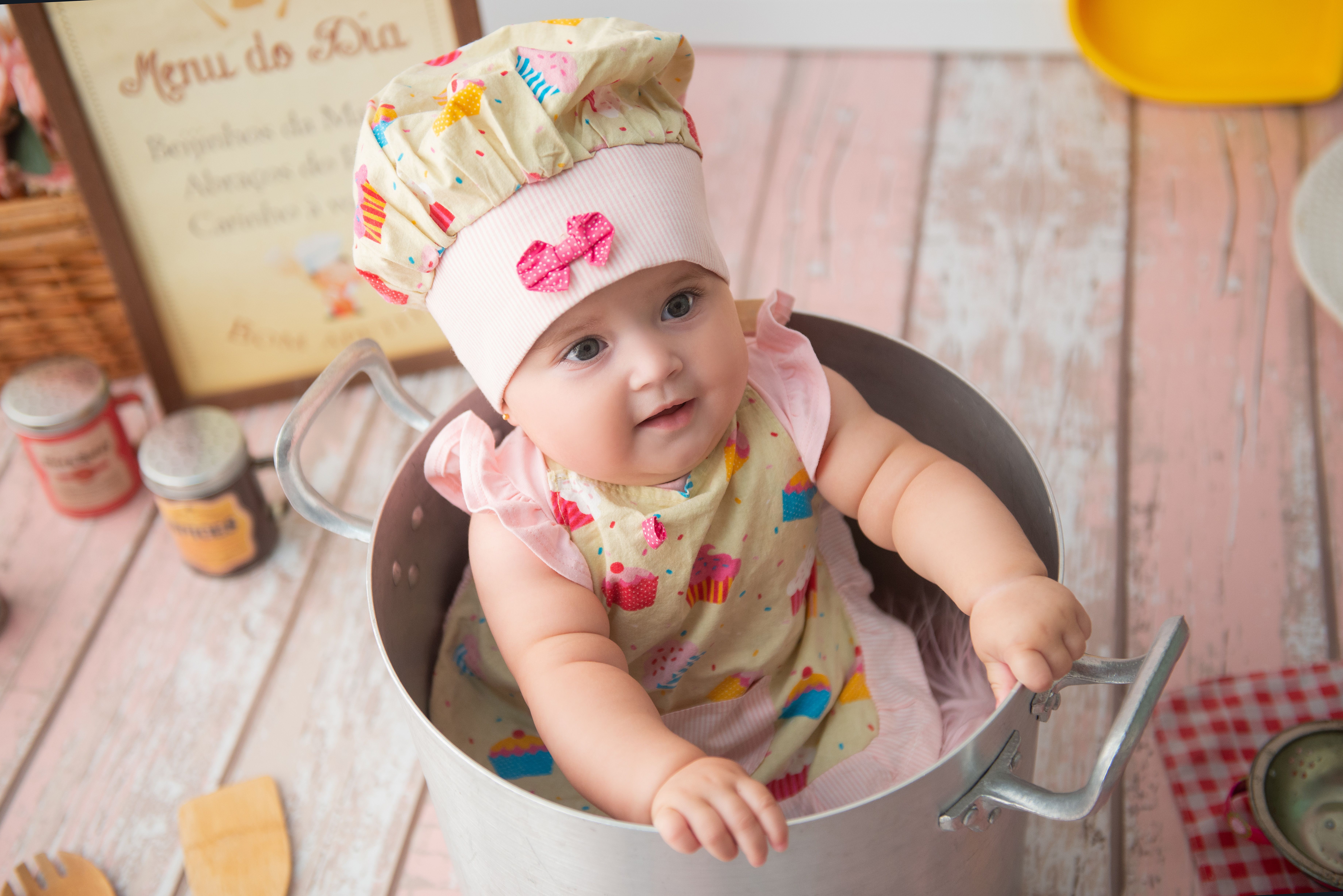 Cute Baby Girl Sitting in a Cooking Pot · Free Stock Photo