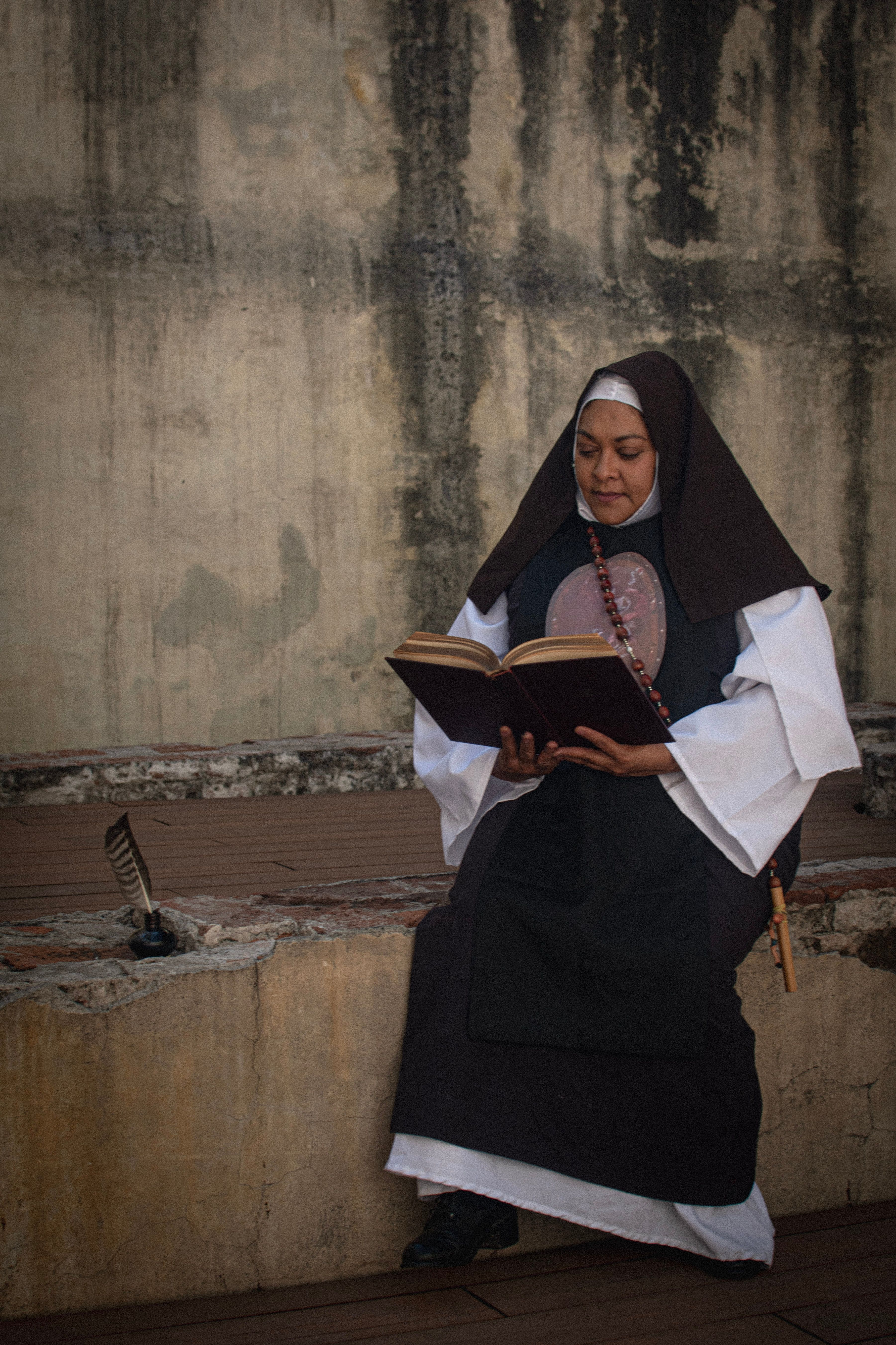 A nun reading a book on a bench · Free Stock Photo