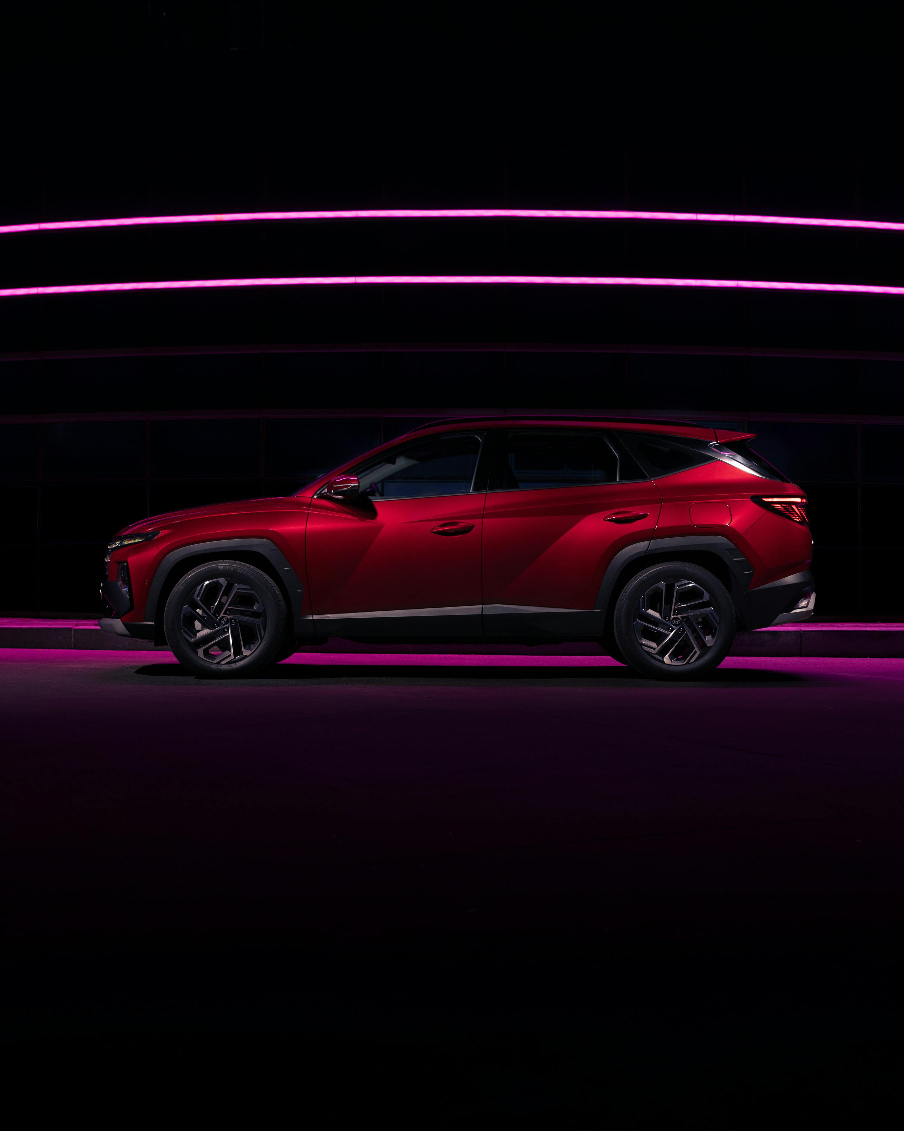 The left side view of the Hyundai Tucson standing under pink lights in the studio. · Free Stock ...