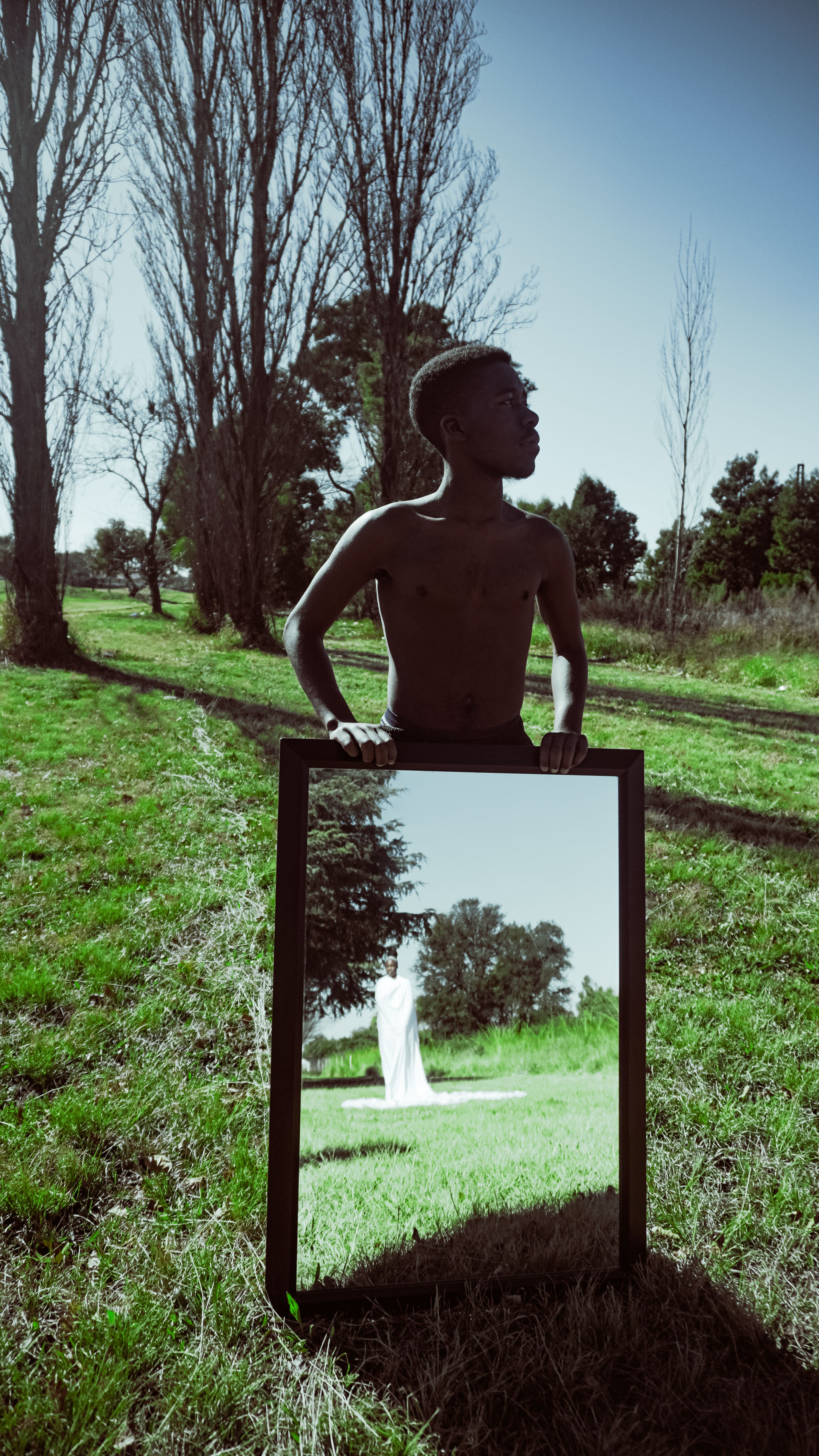 Shirtless Man Standing Outdoors with a Mirror Reflecting a Woman ...