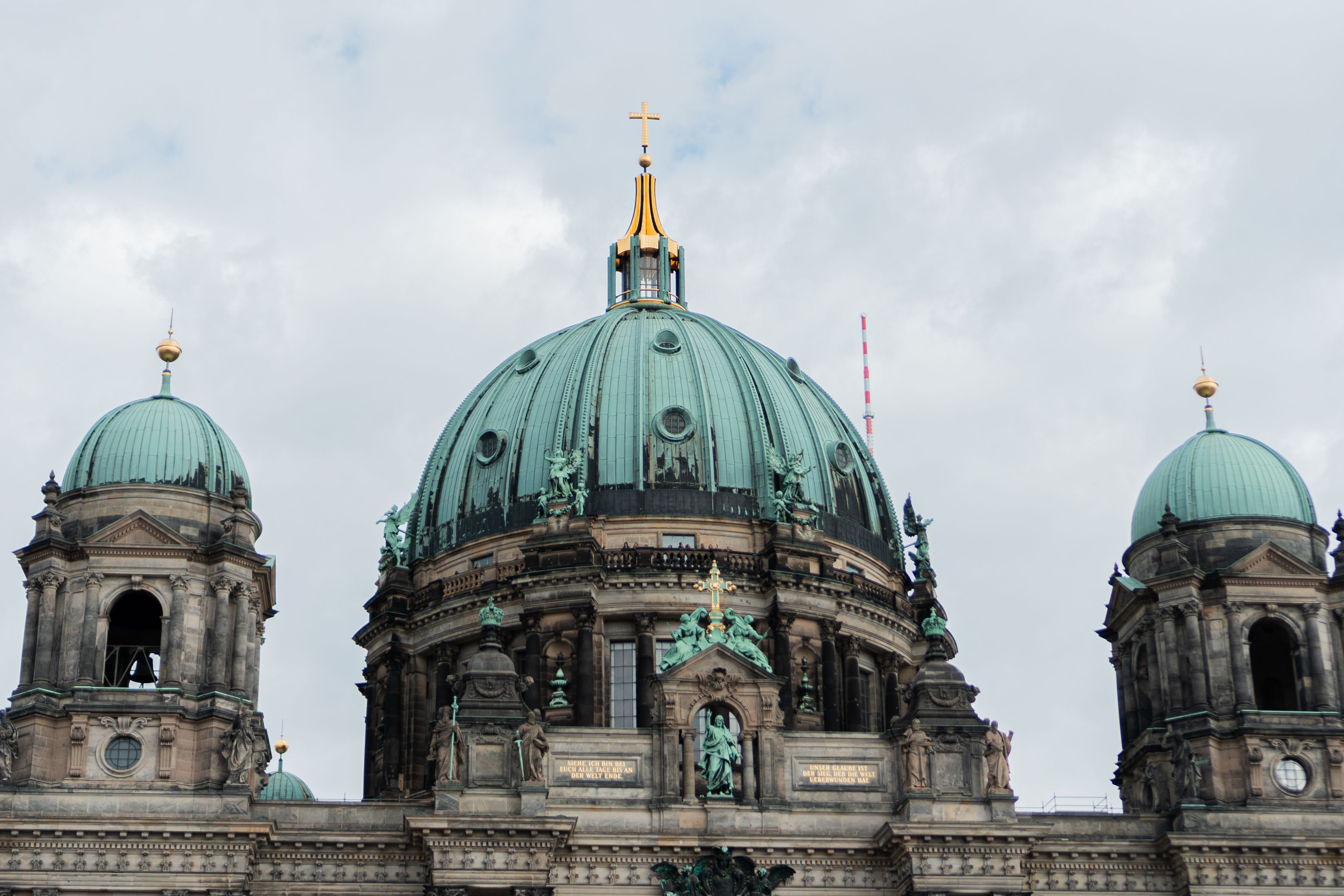 A large building with a dome and two green domes · Free Stock Photo