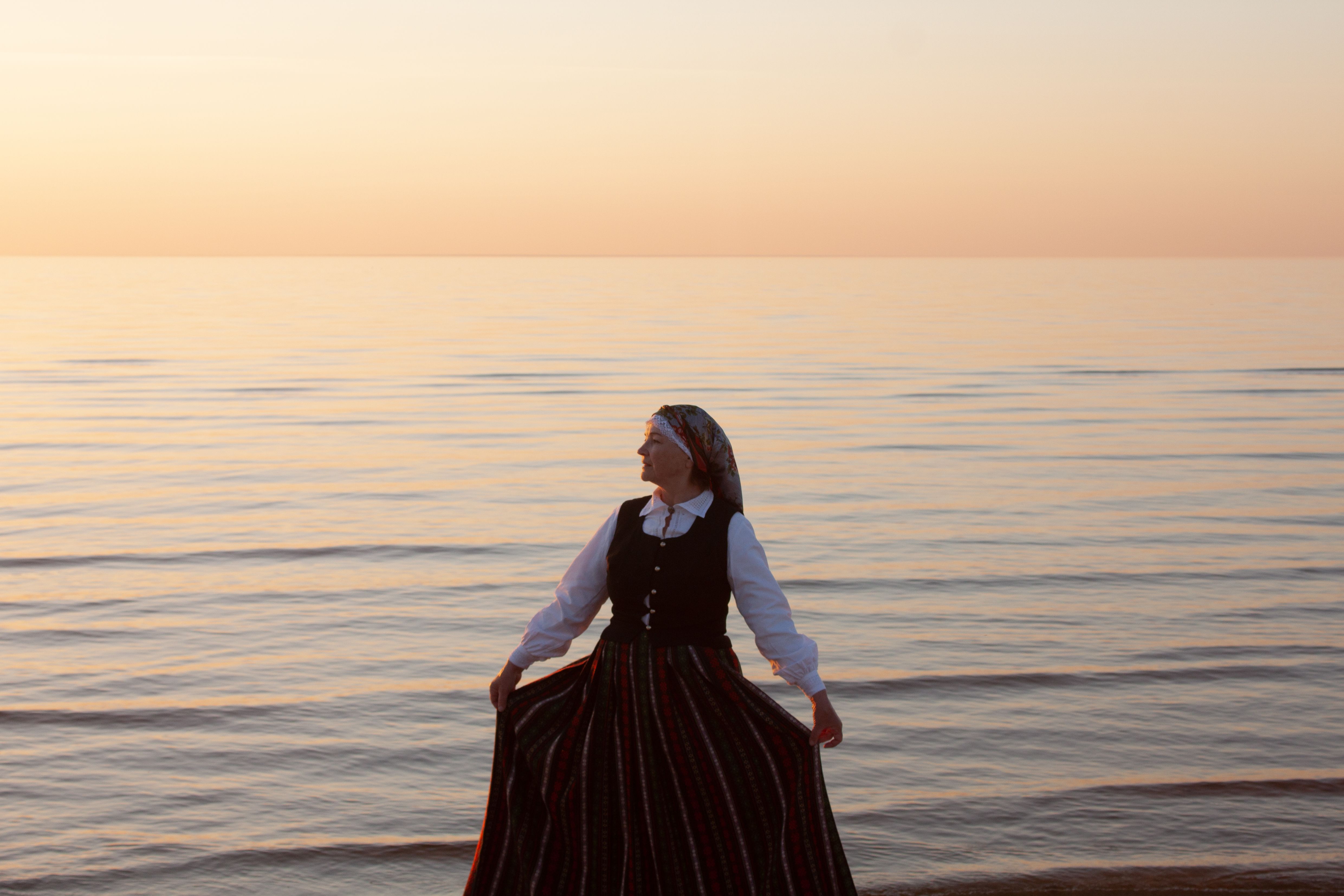 Nun Standing in Ocean at Dusk · Free Stock Photo