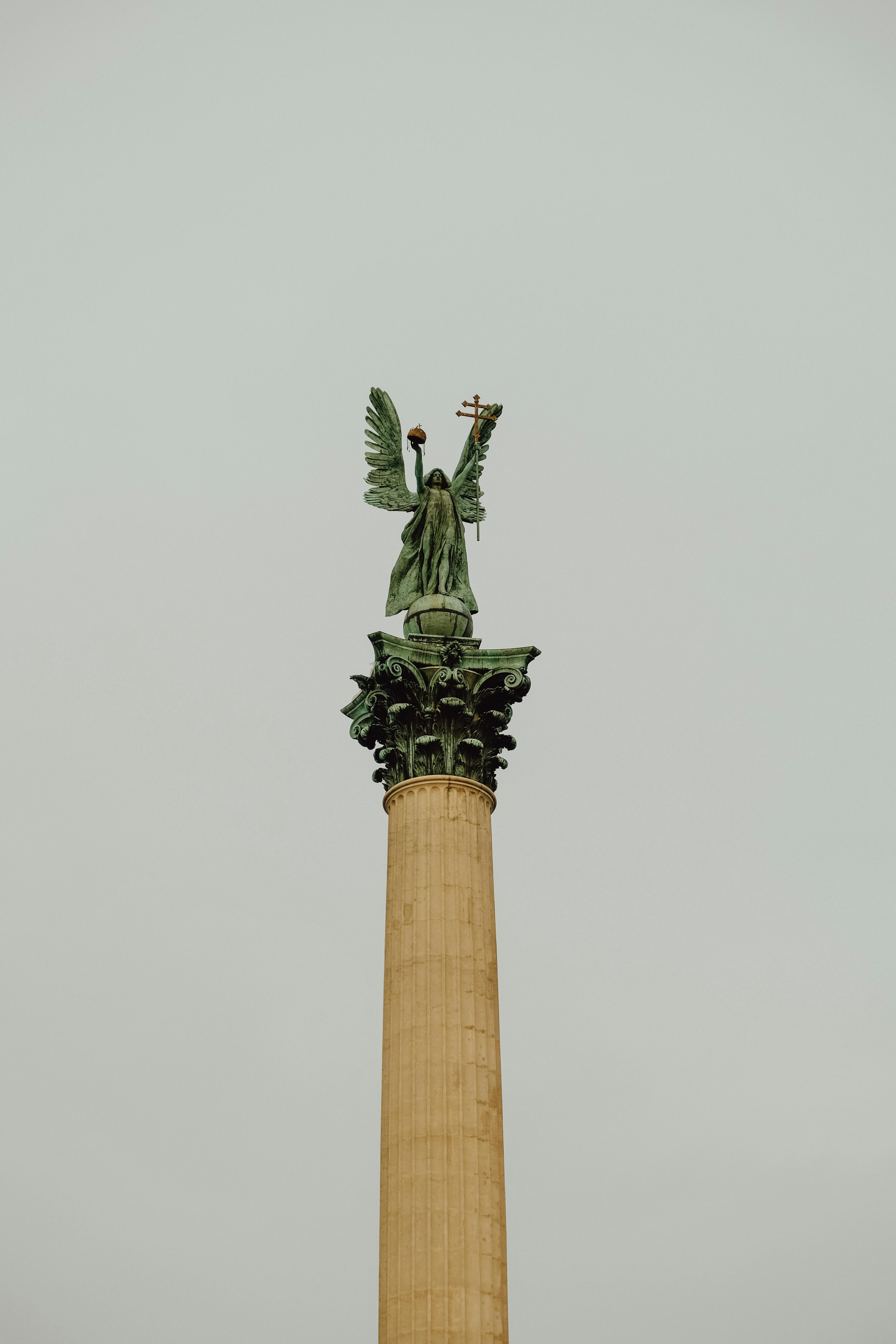 A statue of an angel on top of a column · Free Stock Photo