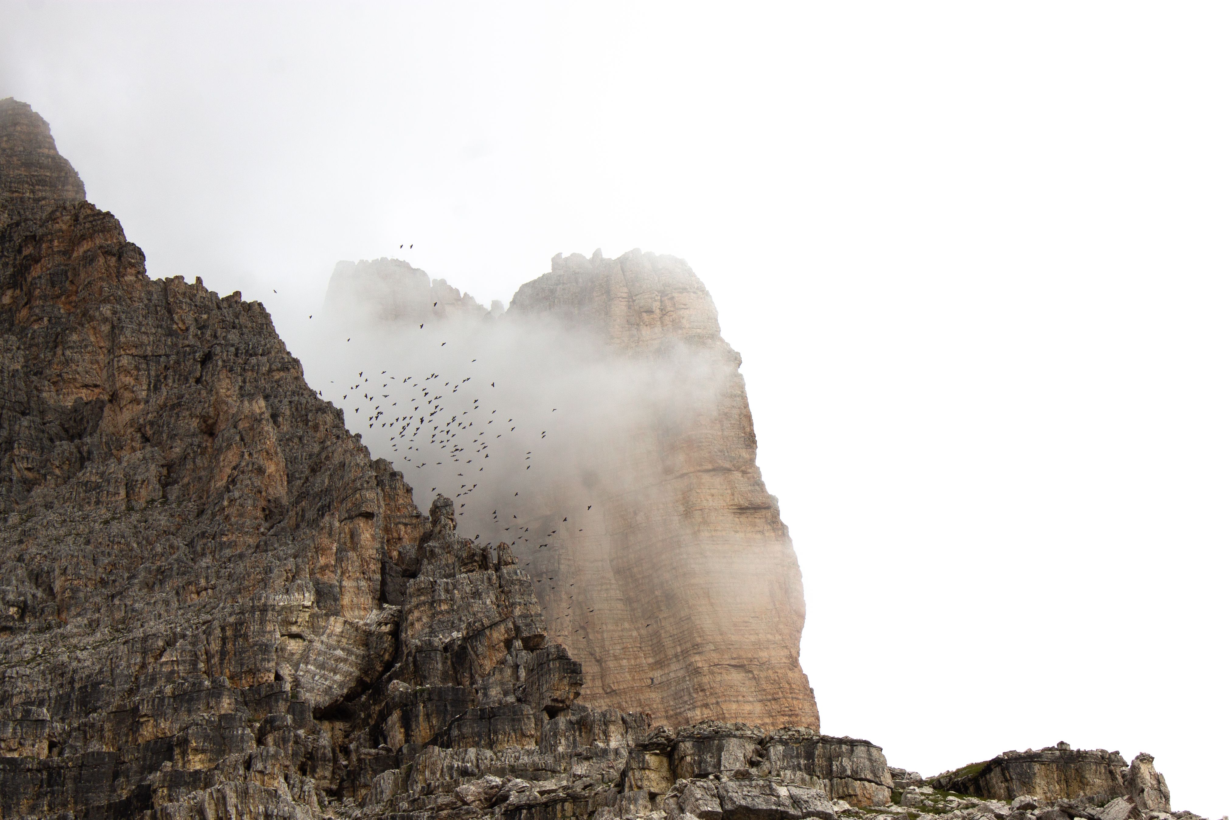 A mountain with a large rock formation in the fog · Free Stock Photo
