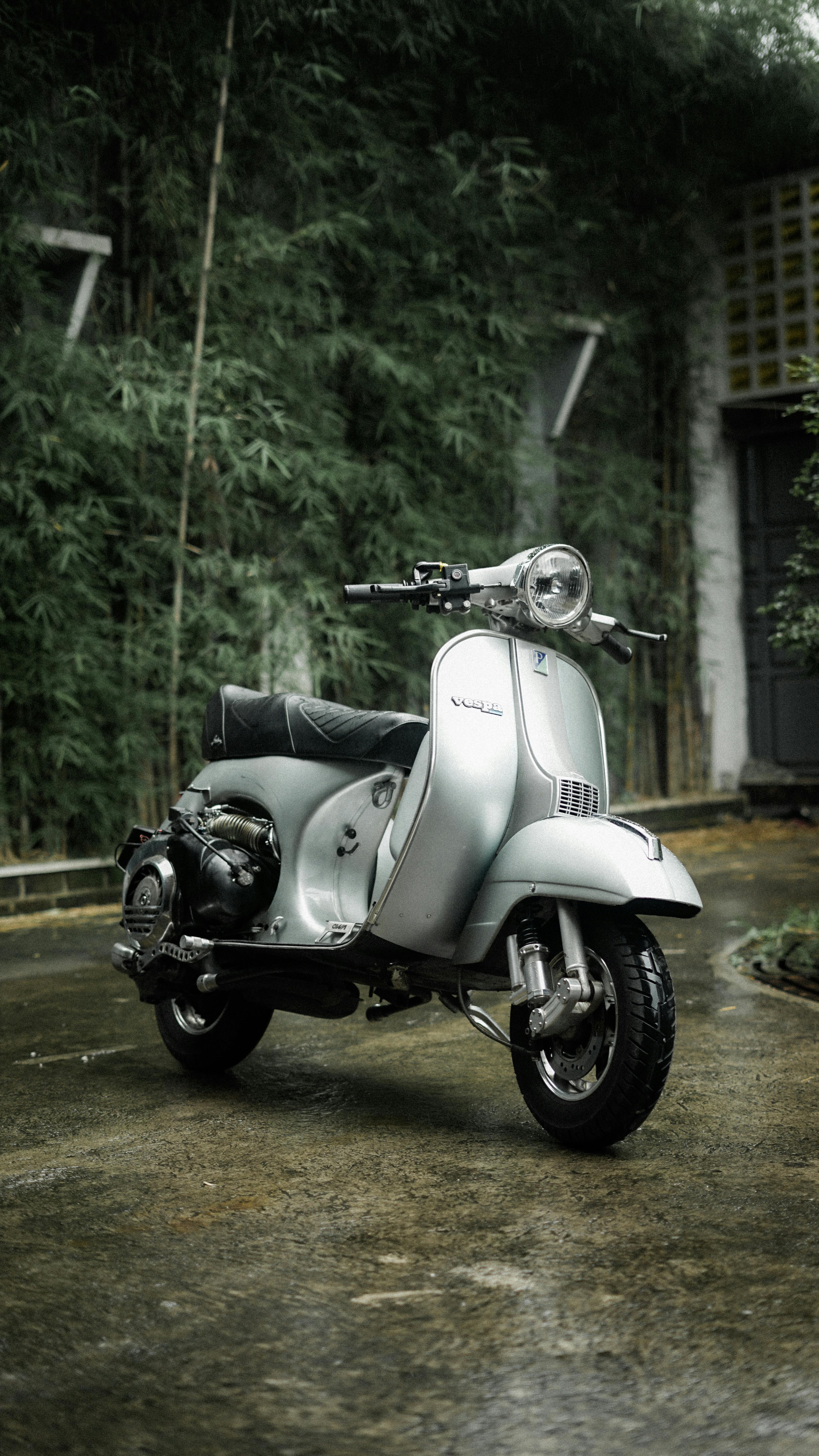 A Silver Motor Scooter Parked on Wet Asphalt · Free Stock Photo
