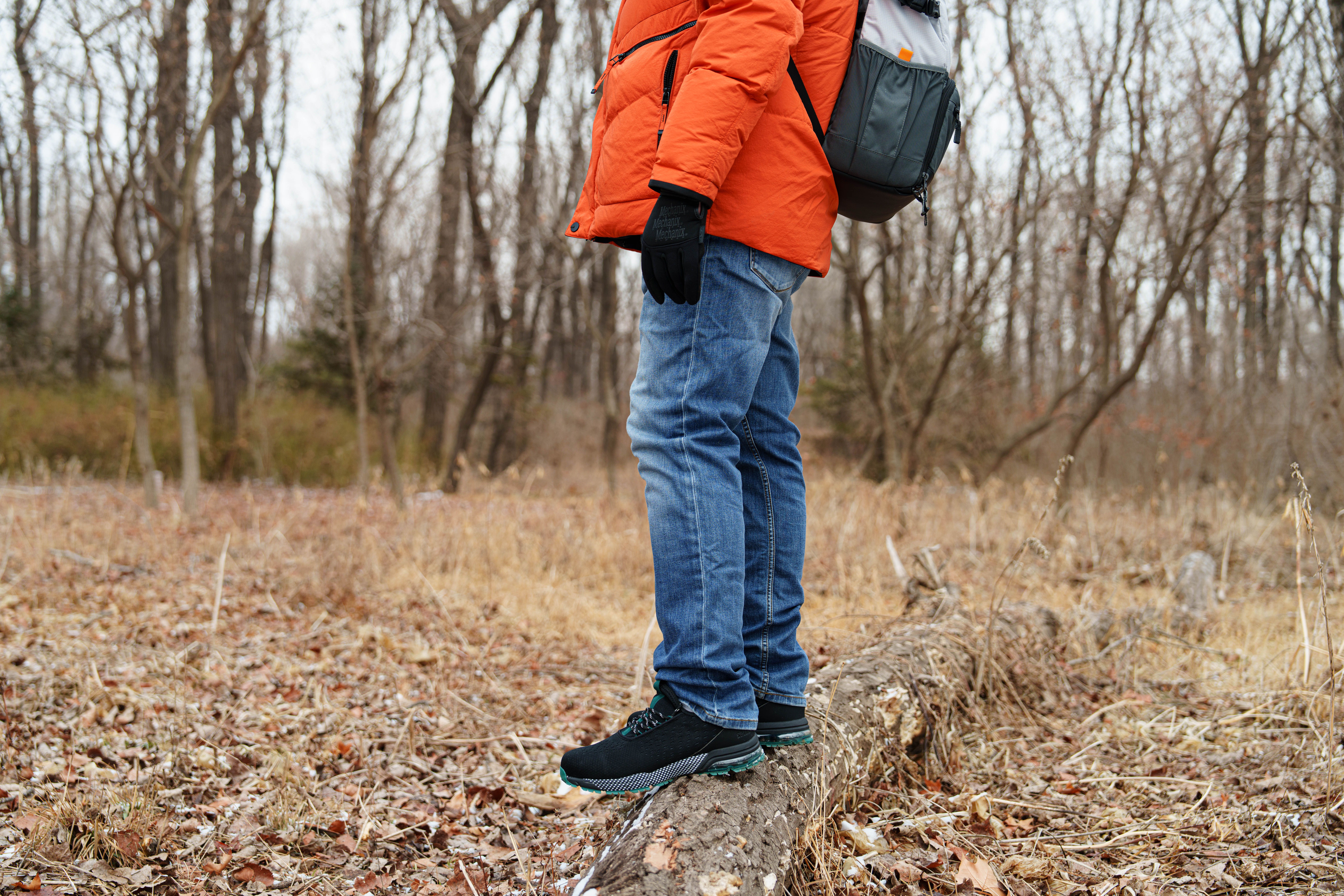 A person standing on a log in the woods · Free Stock Photo