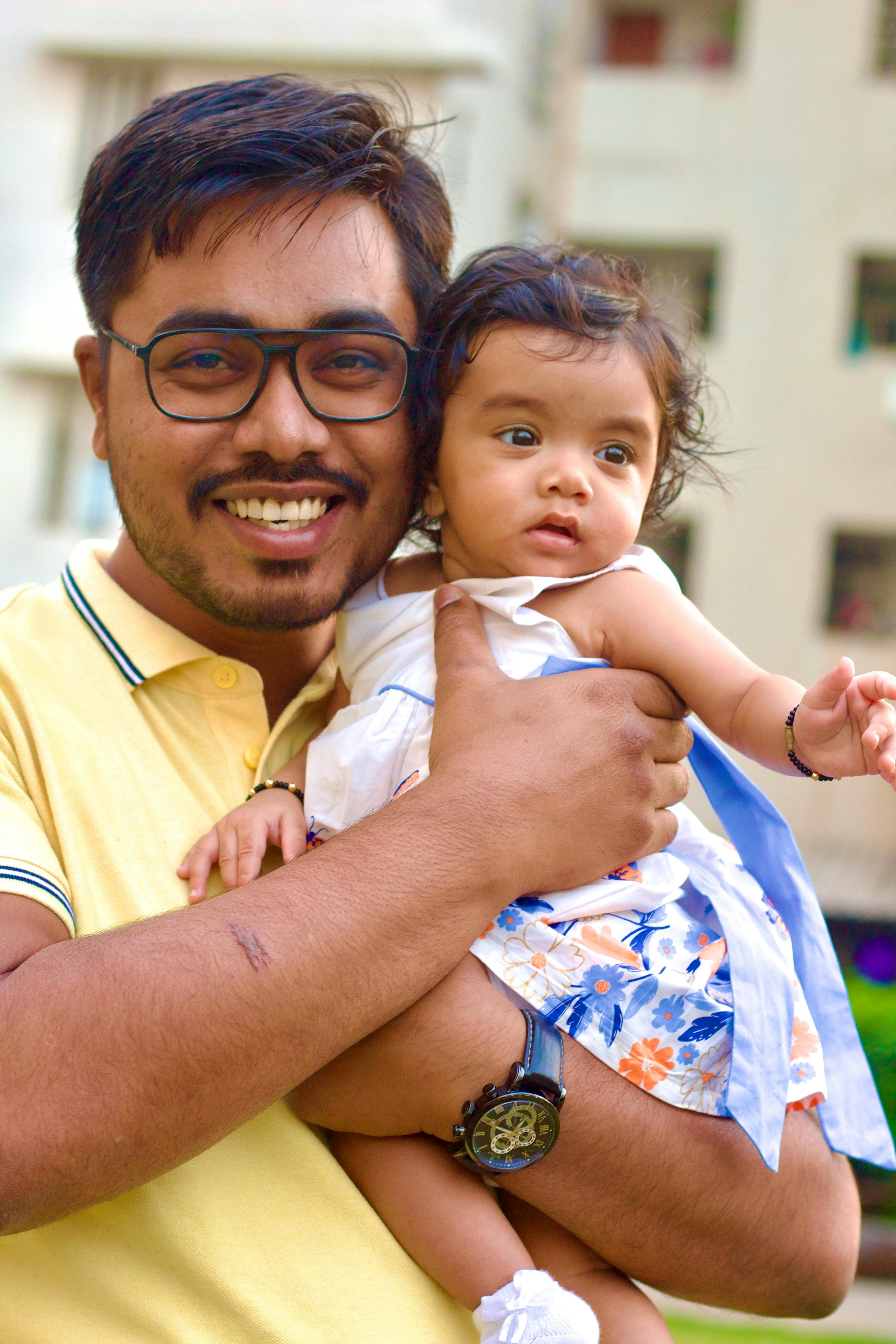 A man holding a baby in his arms · Free Stock Photo