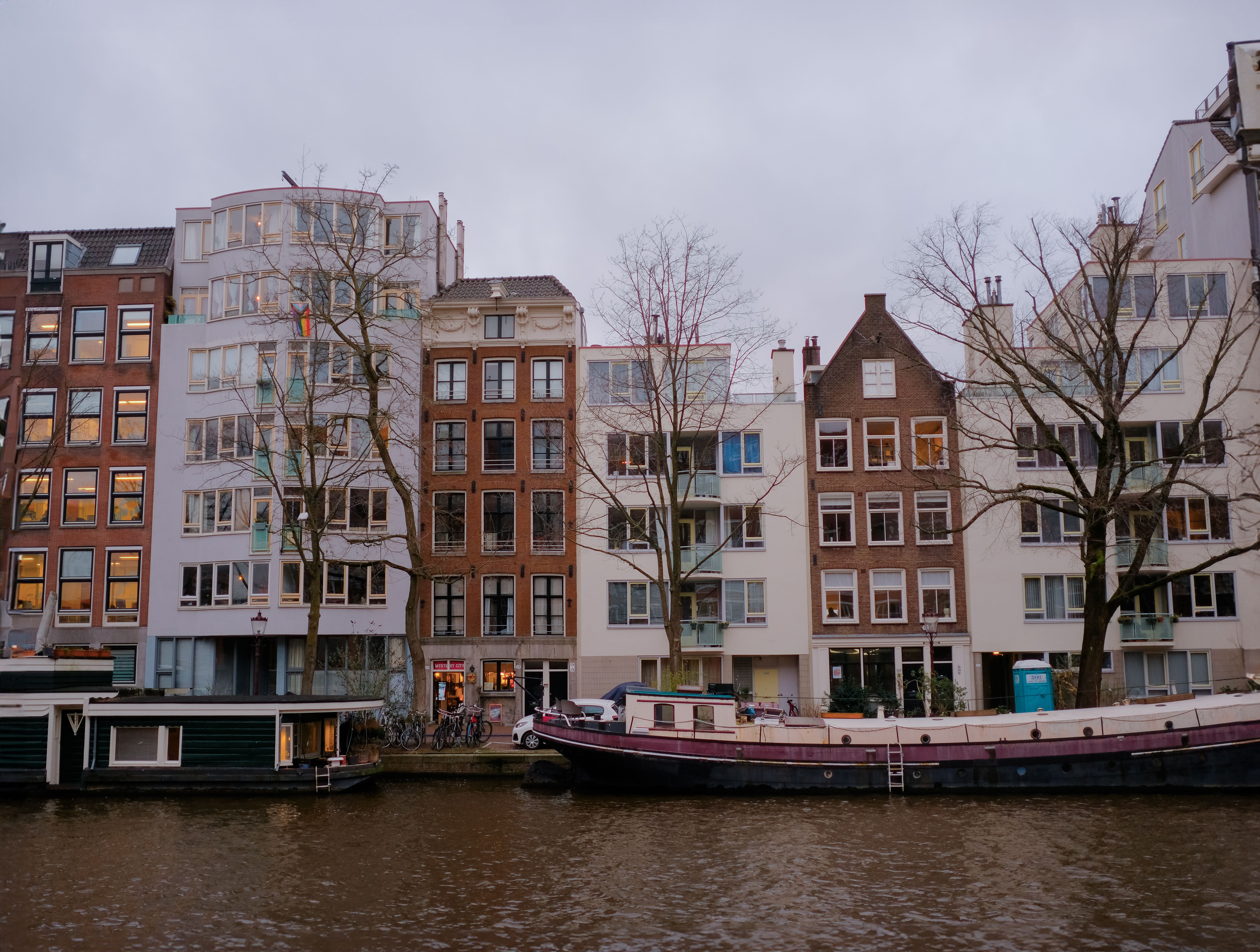 A boat is docked in front of a row of buildings · Free Stock Photo