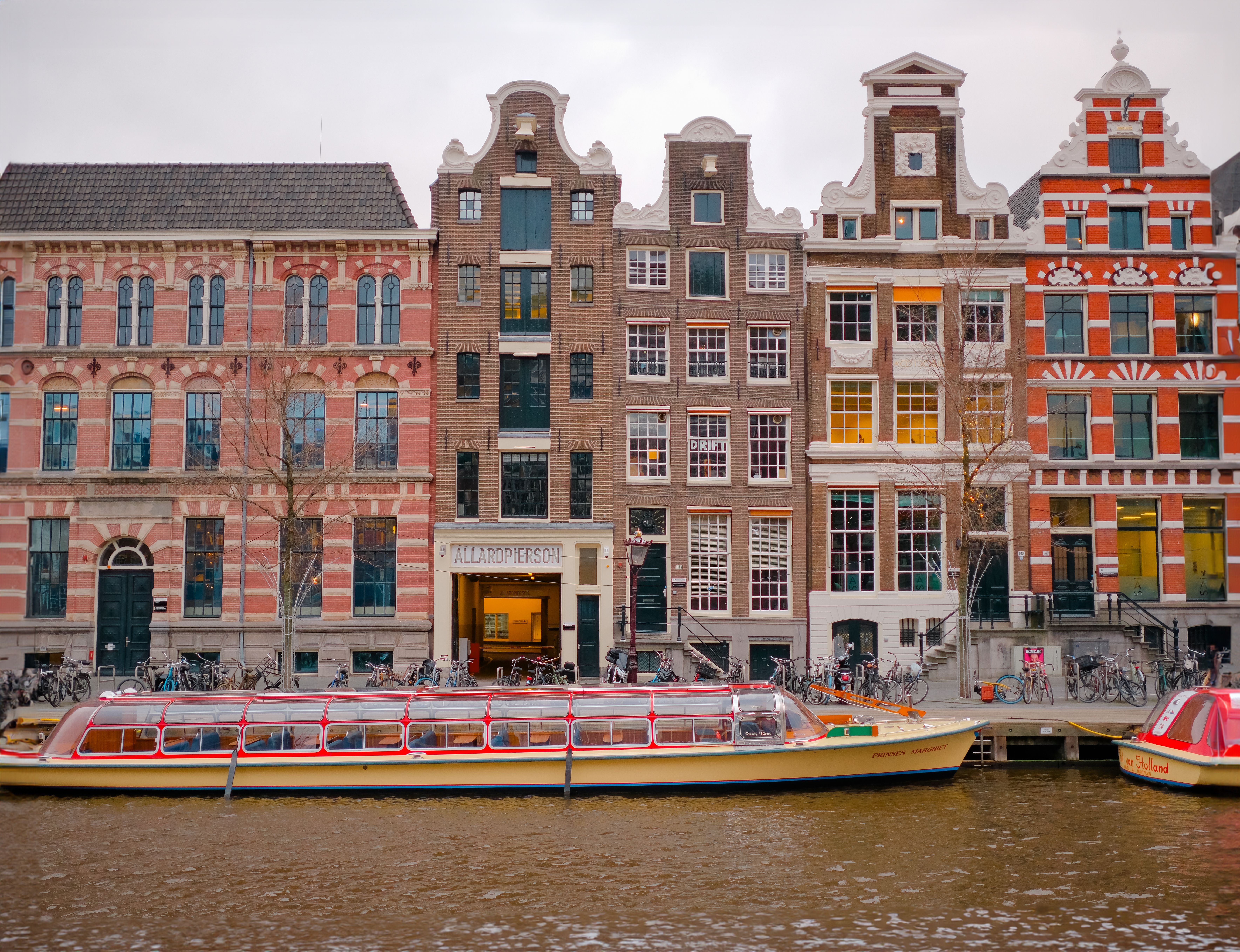 A boat is docked in front of a row of buildings · Free Stock Photo