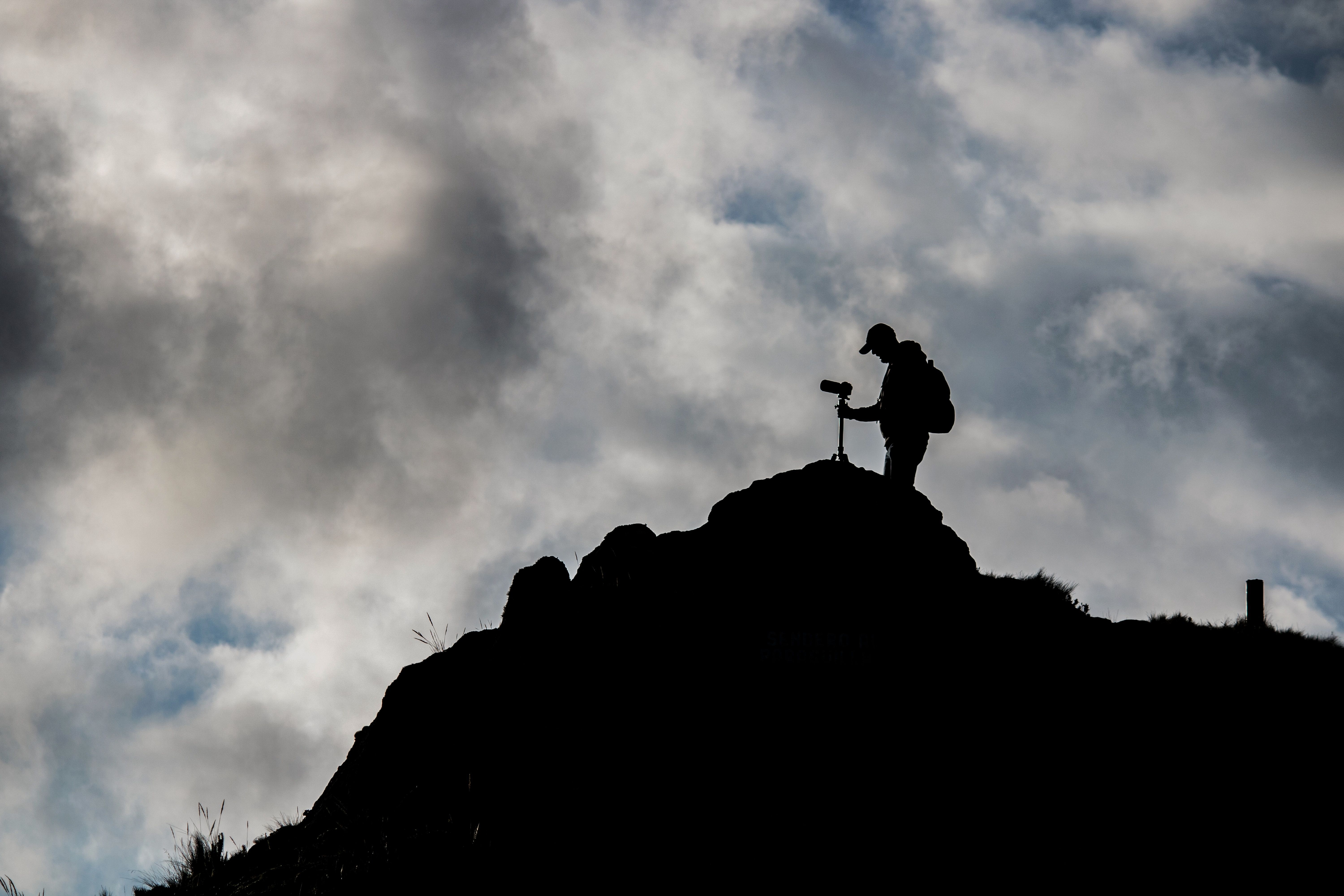 Silhouette of Man Standing with Camera on Hill · Free Stock Photo