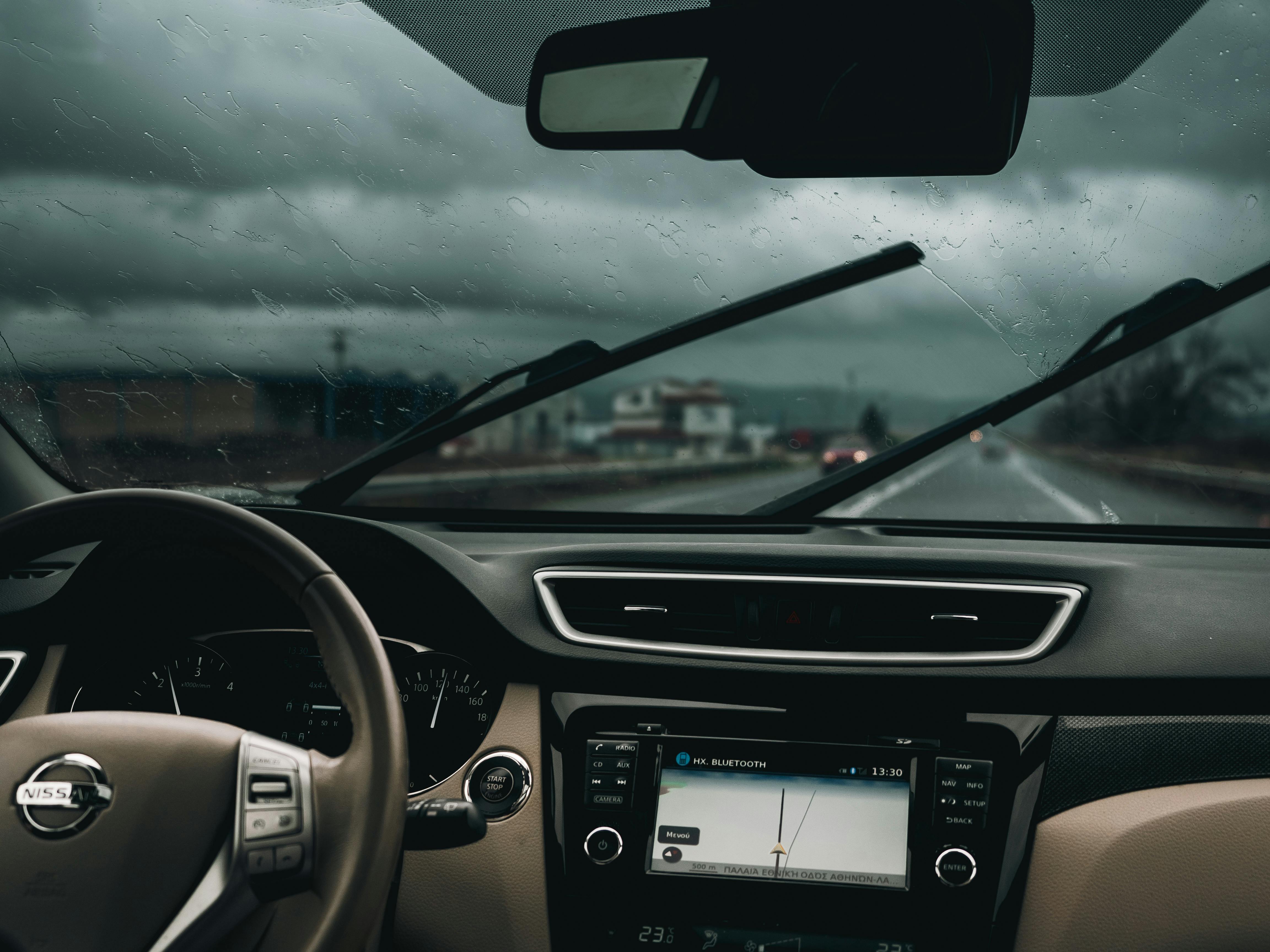 A dashboard view of a car with windshield wipers · Free Stock Photo