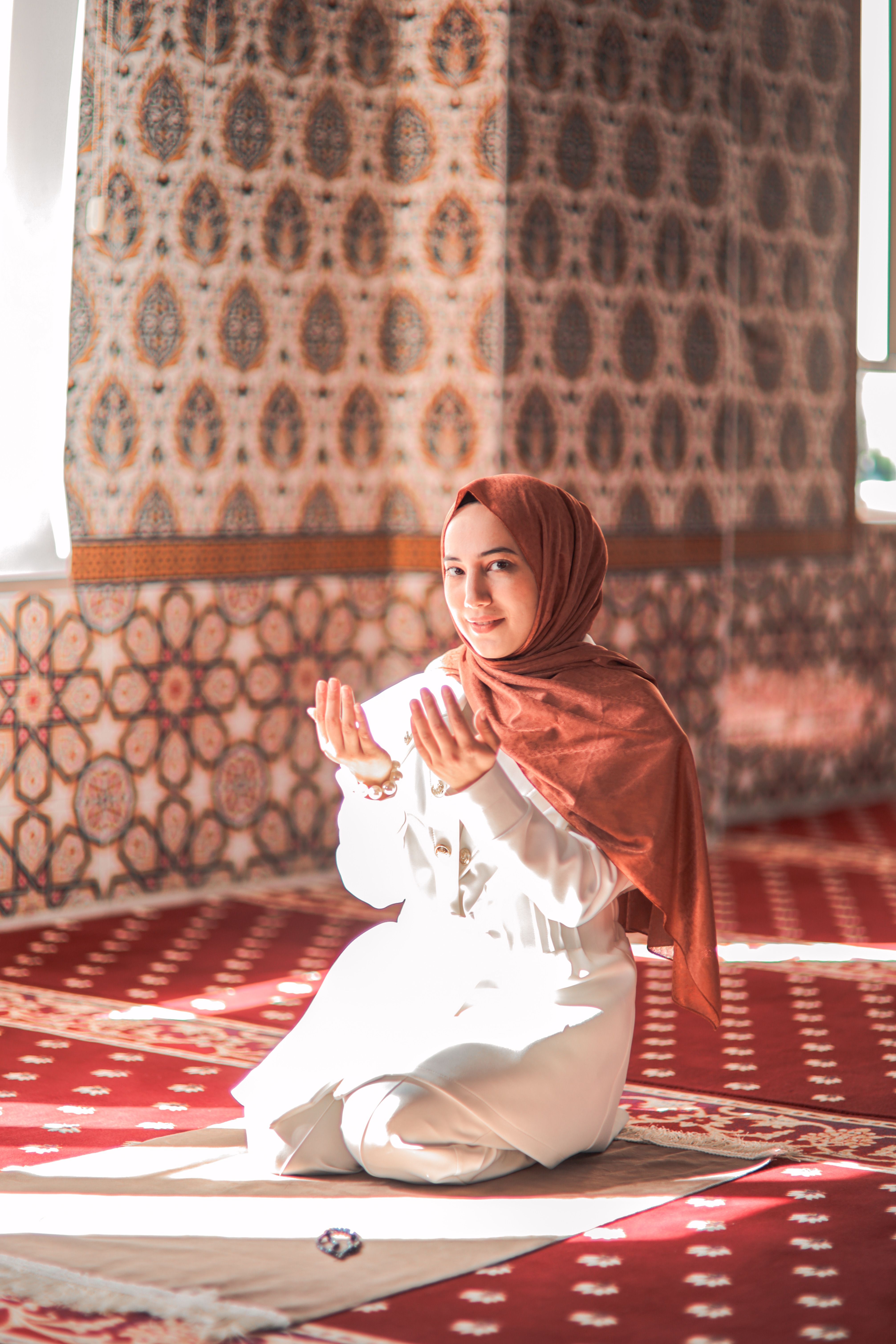 Woman in Hijab Kneeling and Praying at Mosque · Free Stock Photo