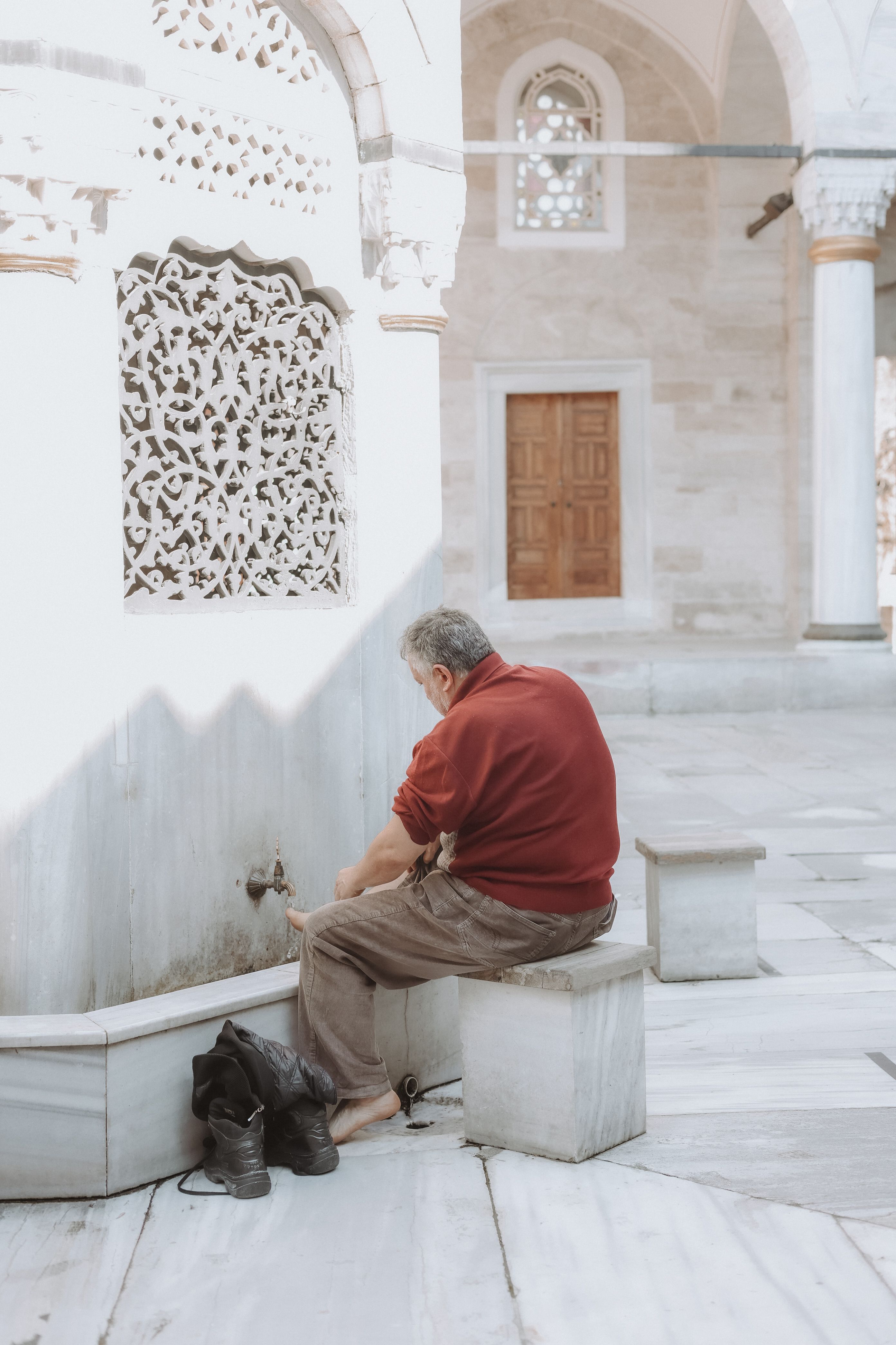 Un Homme Assis Dans La Zone Des Ablutions à La Mosquée · Photo gratuite