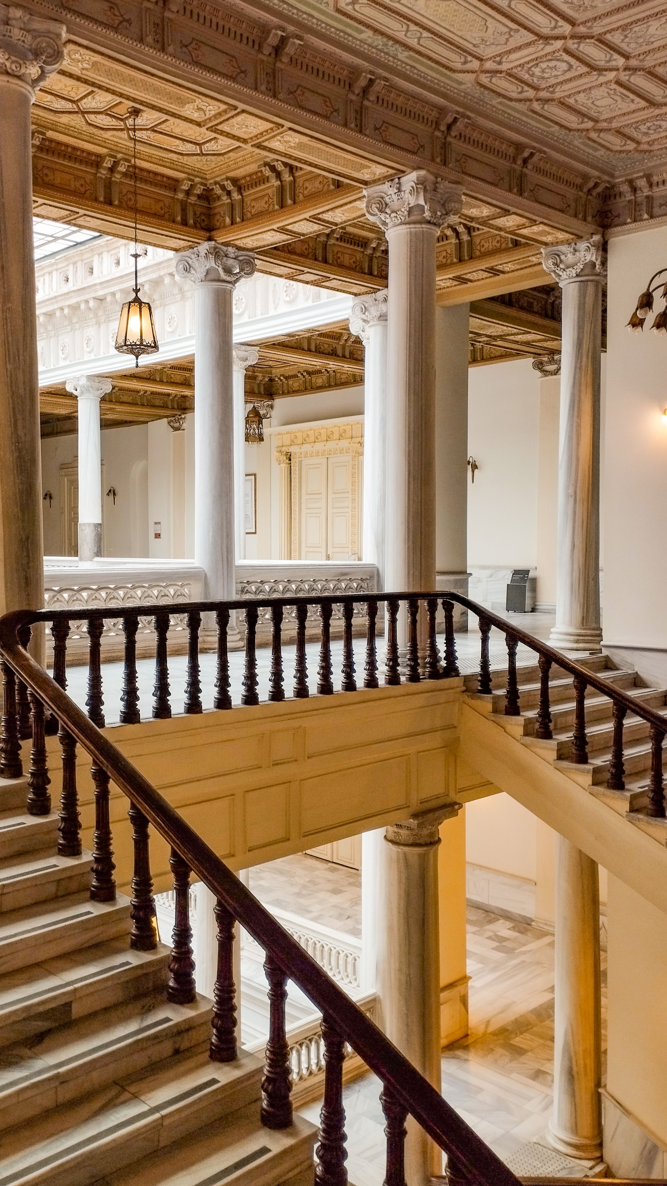 The staircase in the building has columns and a ceiling · Free Stock Photo