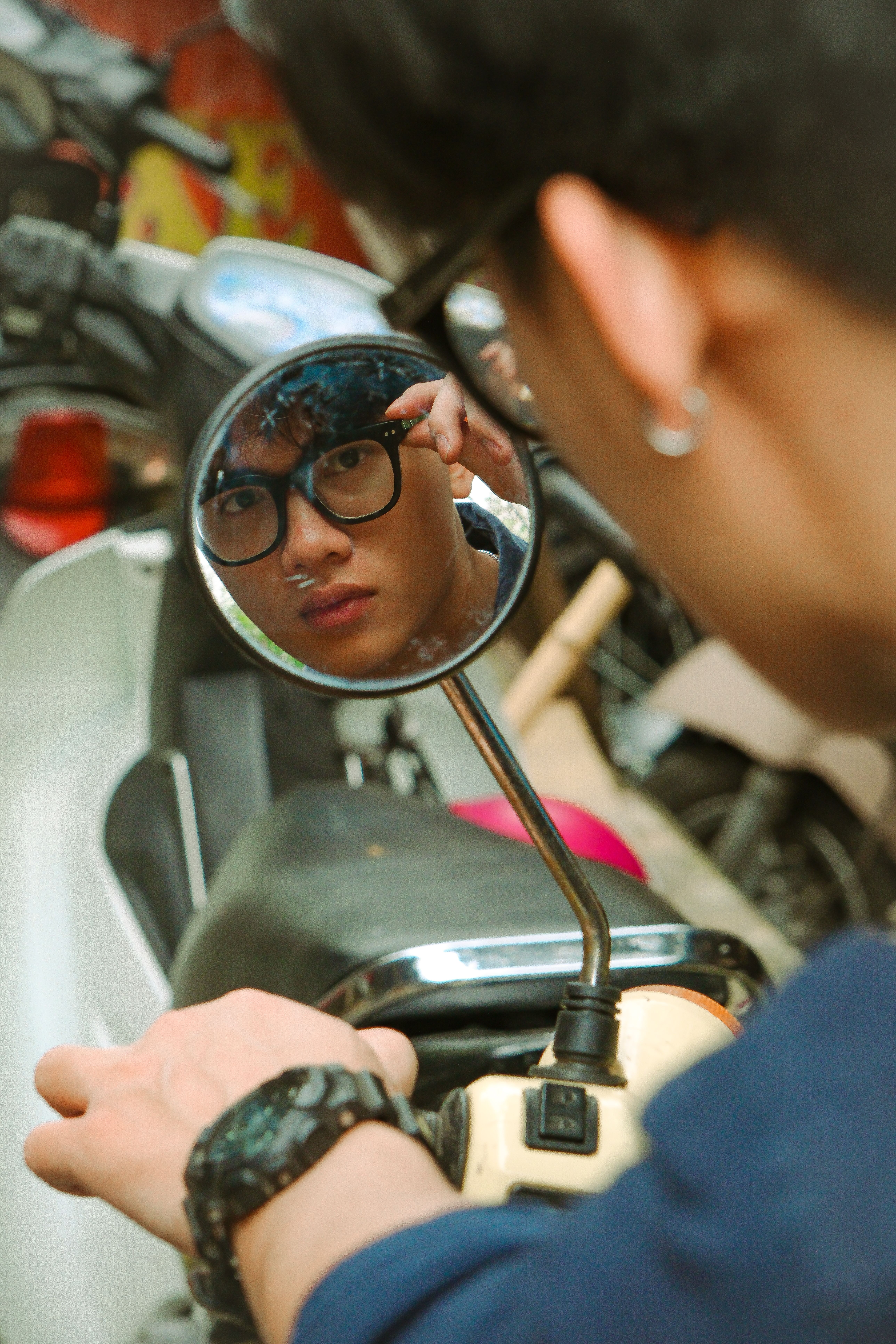 A man looking in a mirror on a motorcycle · Free Stock Photo
