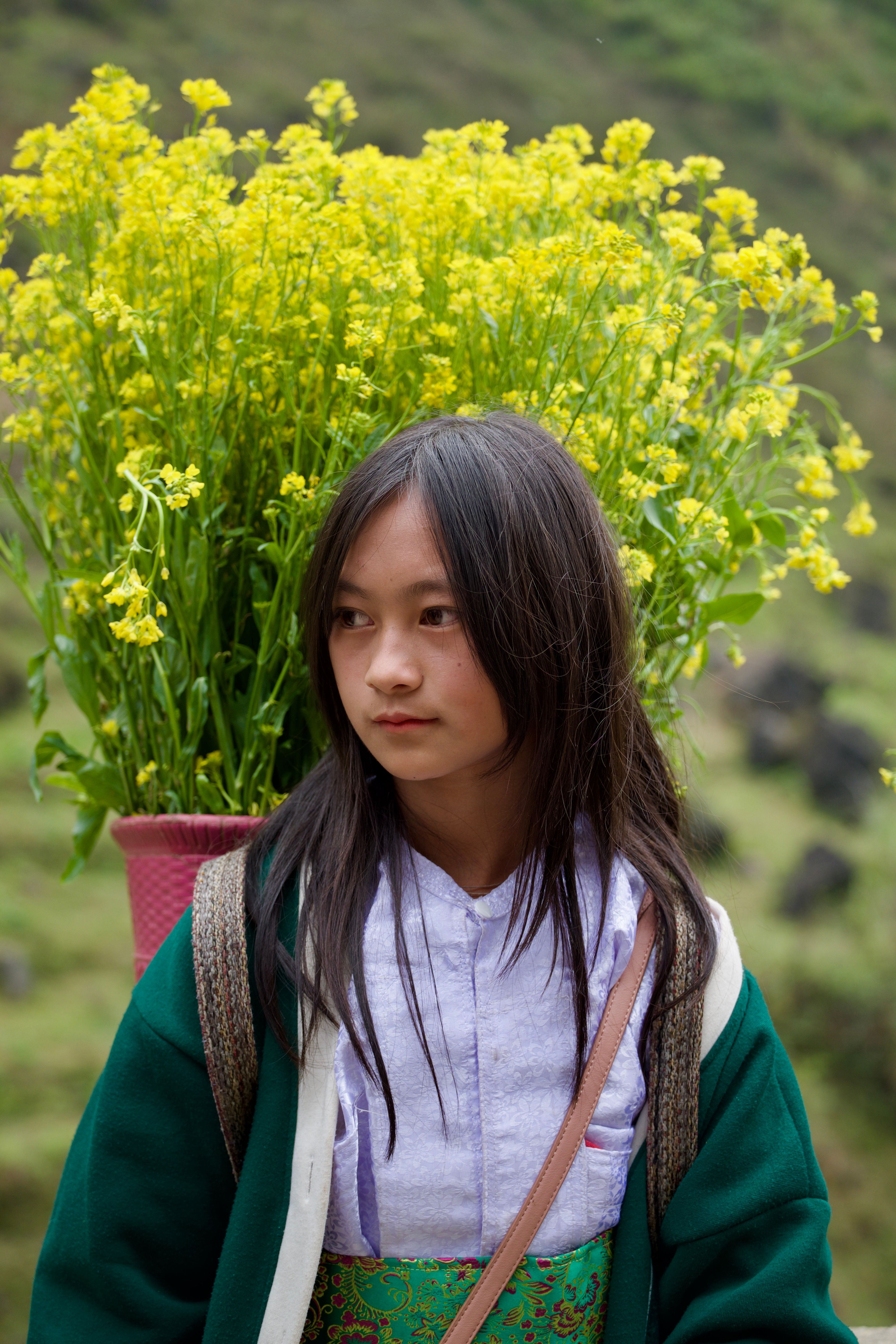 Girl with Rapsflower on Her Back · Free Stock Photo