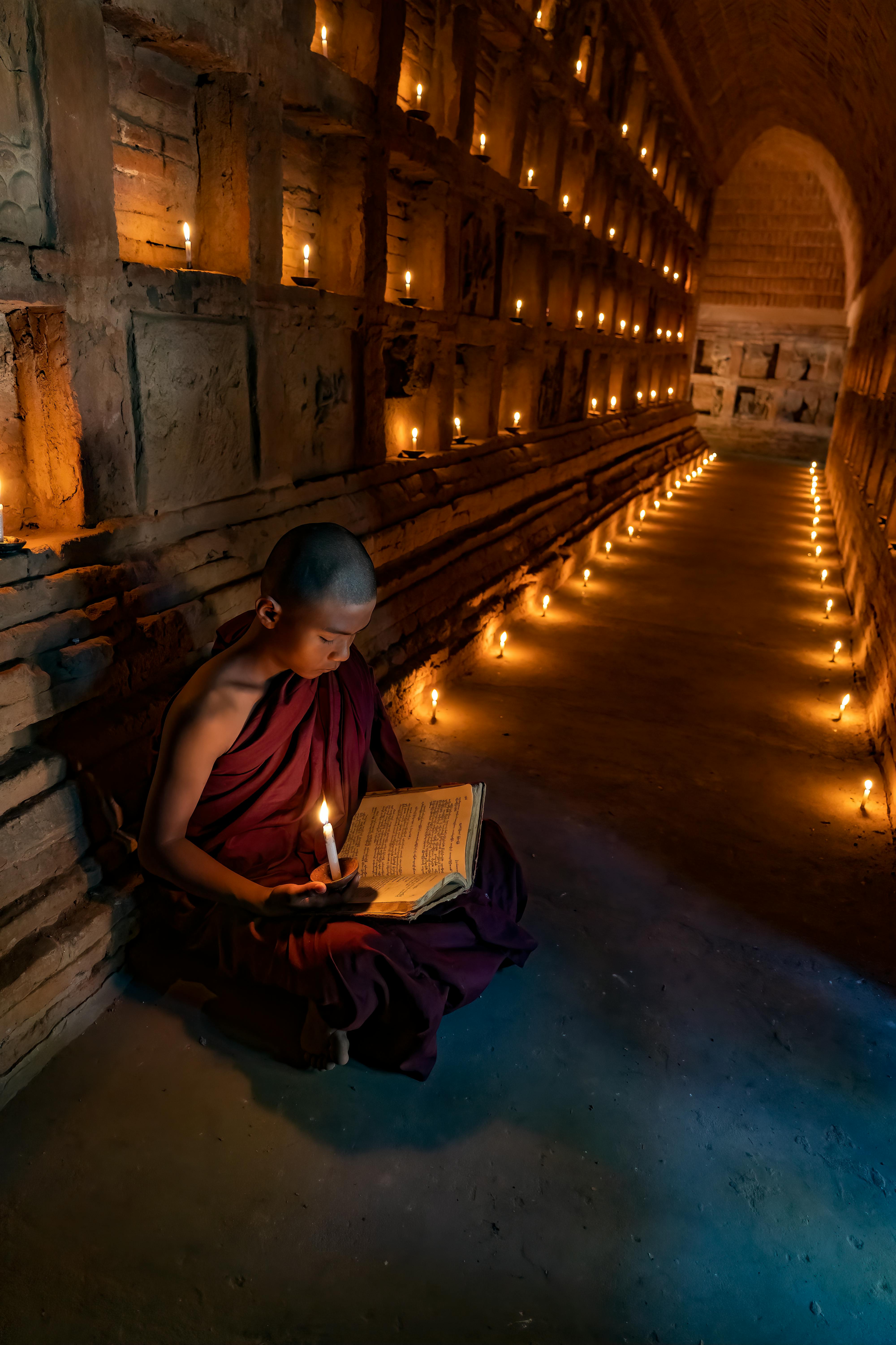 Child in Buddhist Monk Robes Sitting with Candles and Reading Book ...