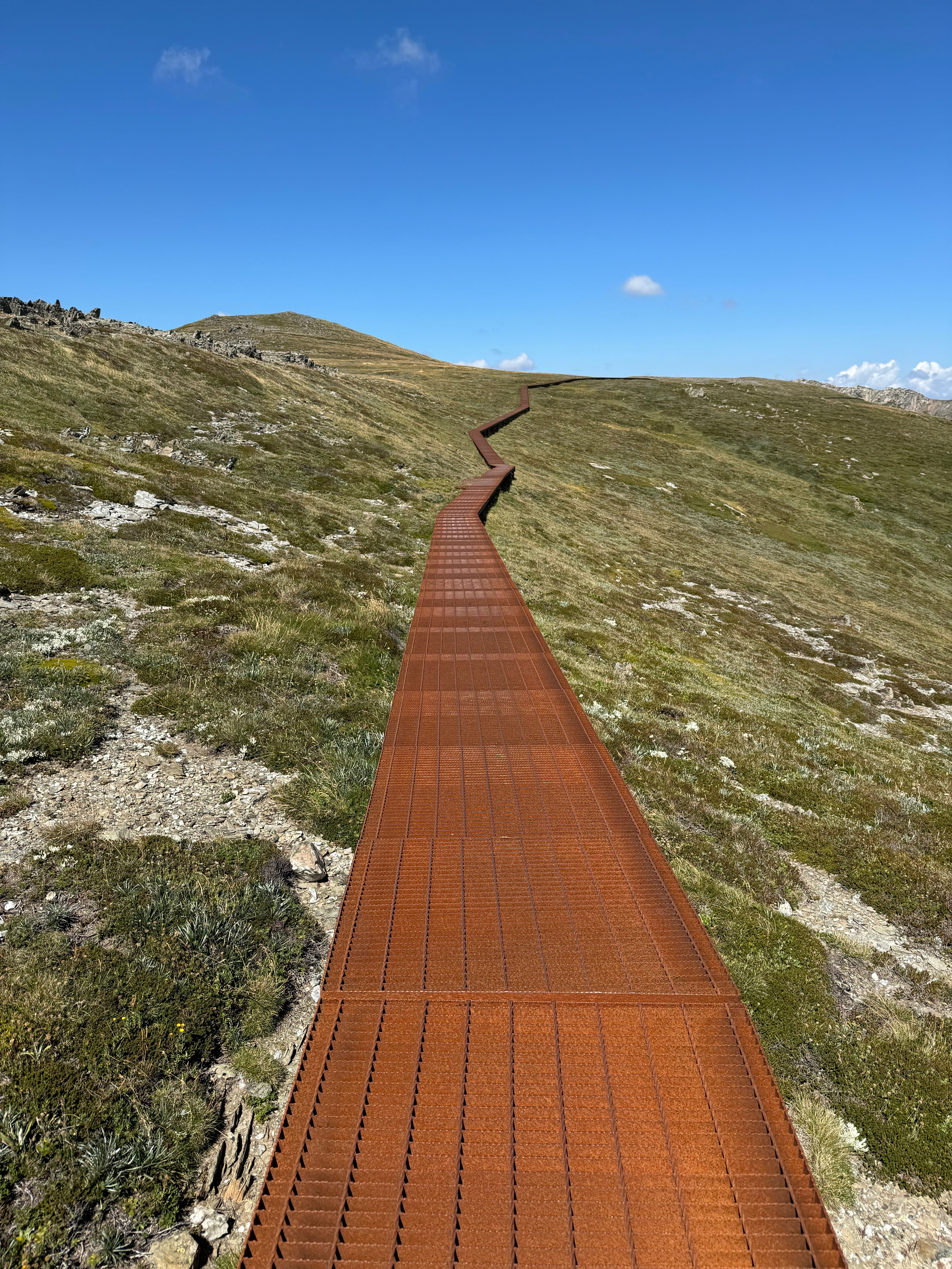 A long walkway on a mountain with a metal railing · Free Stock Photo