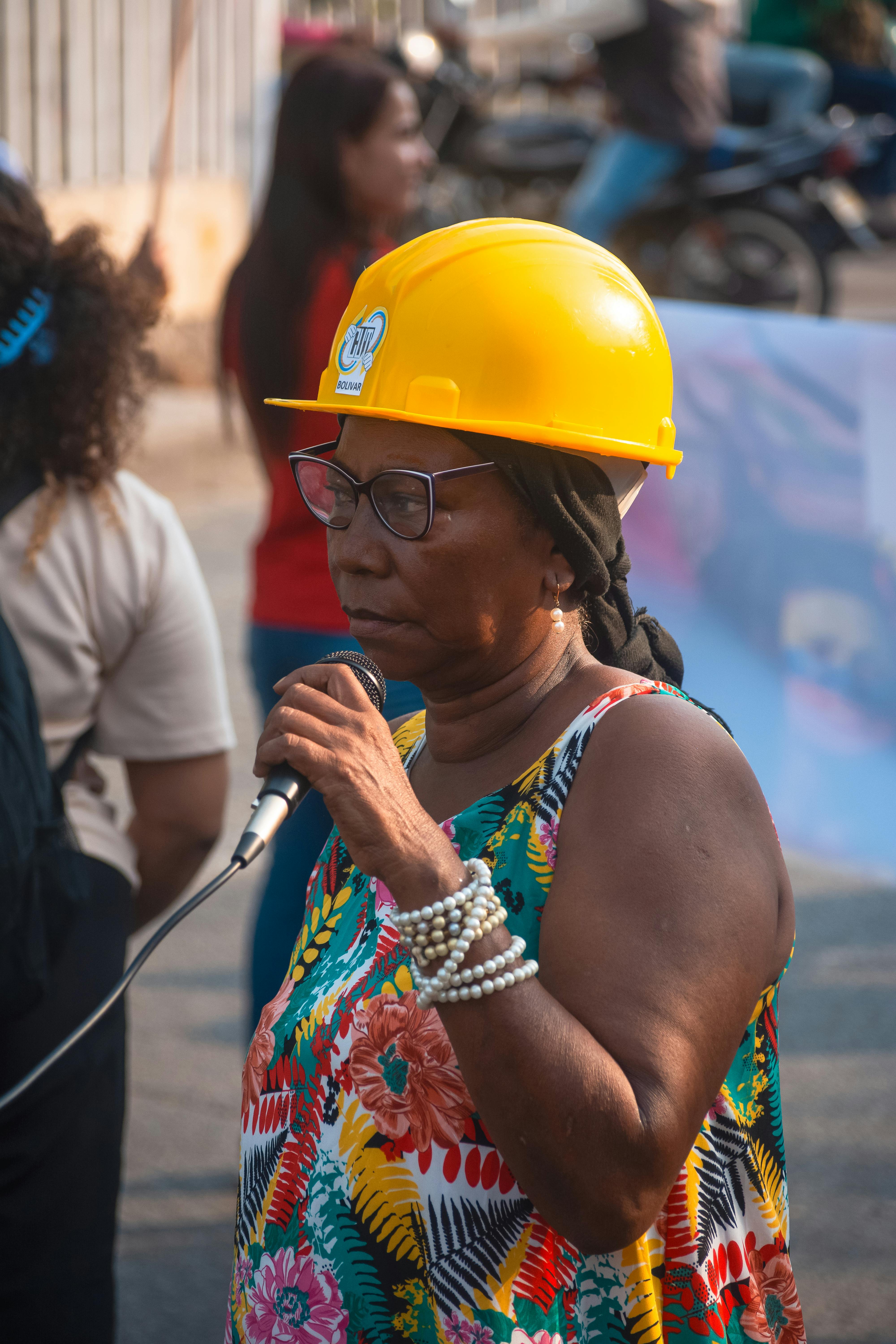 Woman in Helmet and Eyeglasses Standing with Microphone at ...