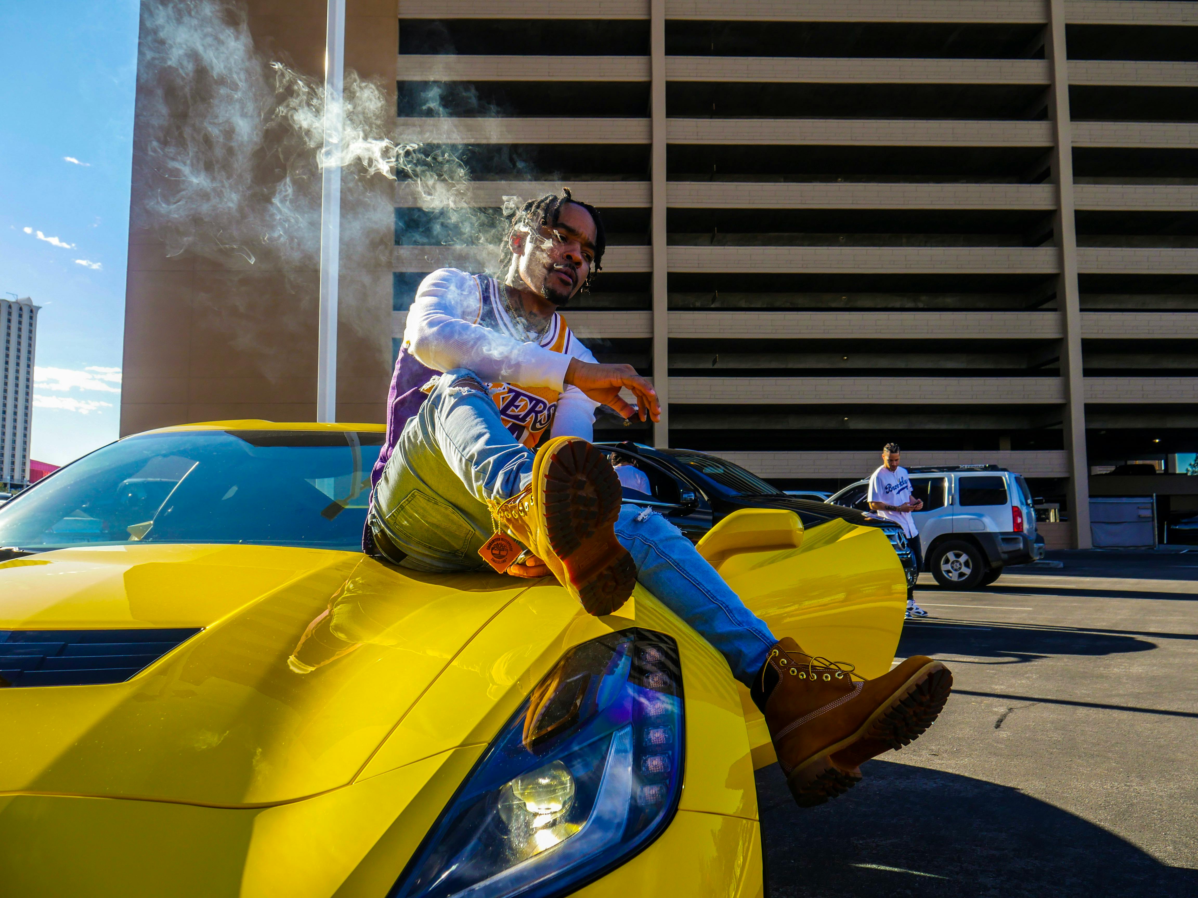 Photo of Man Sitting on Yellow Corvette Stingray · Free Stock Photo