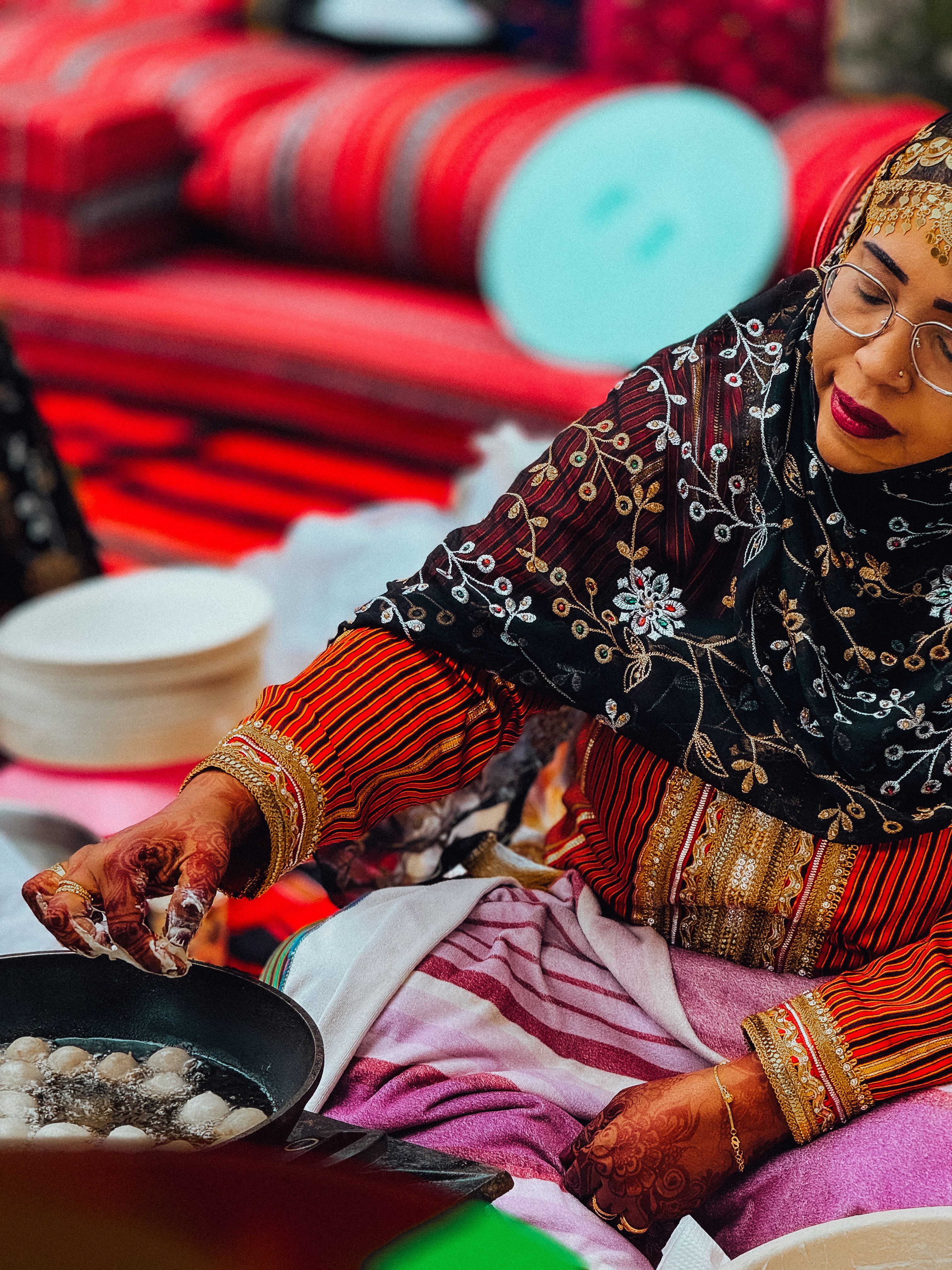 A Woman in Traditional Clothing Sitting and Cooking · Free Stock Photo