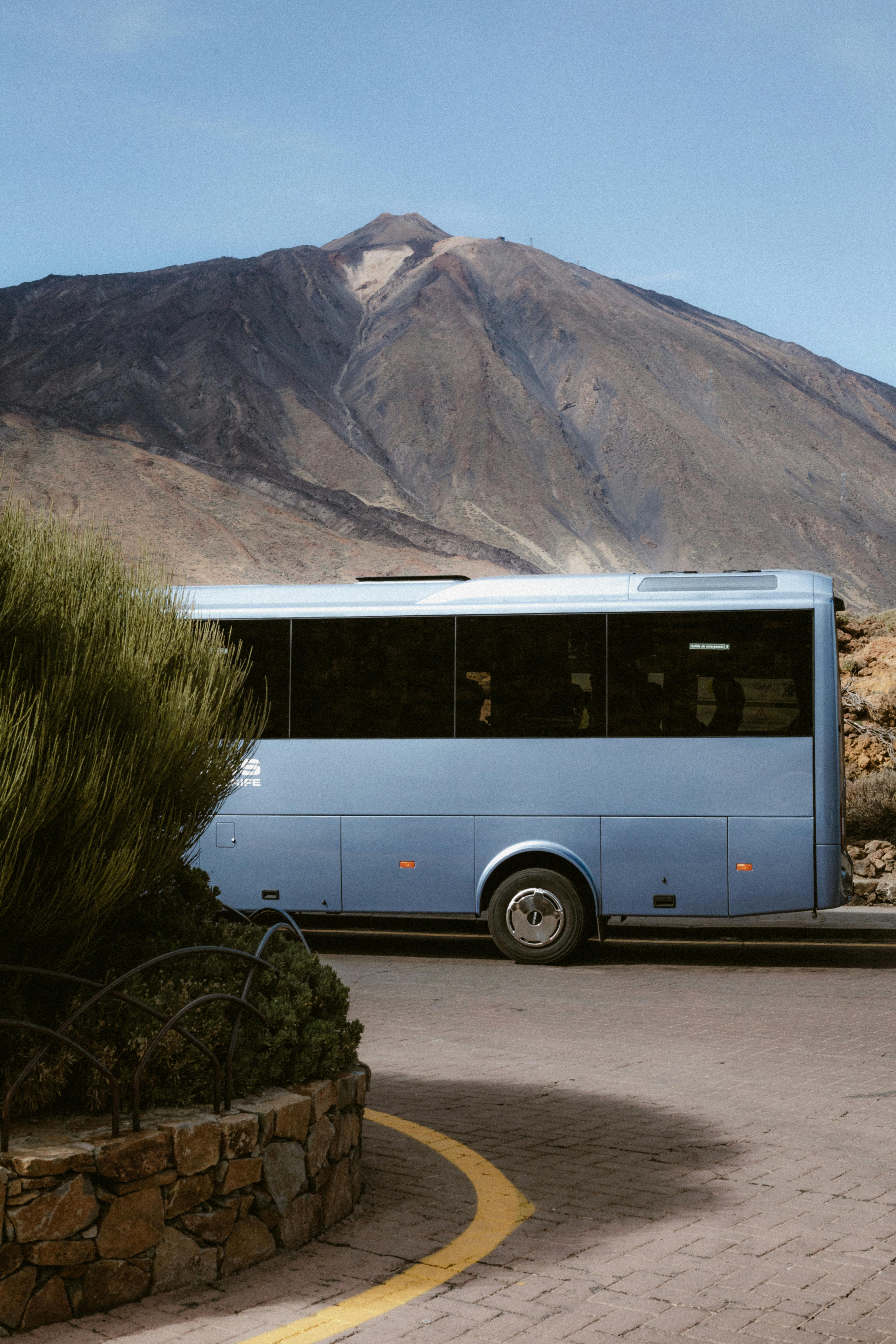 Back of a Blue Bus with a Mountain in the Background · Free Stock Photo