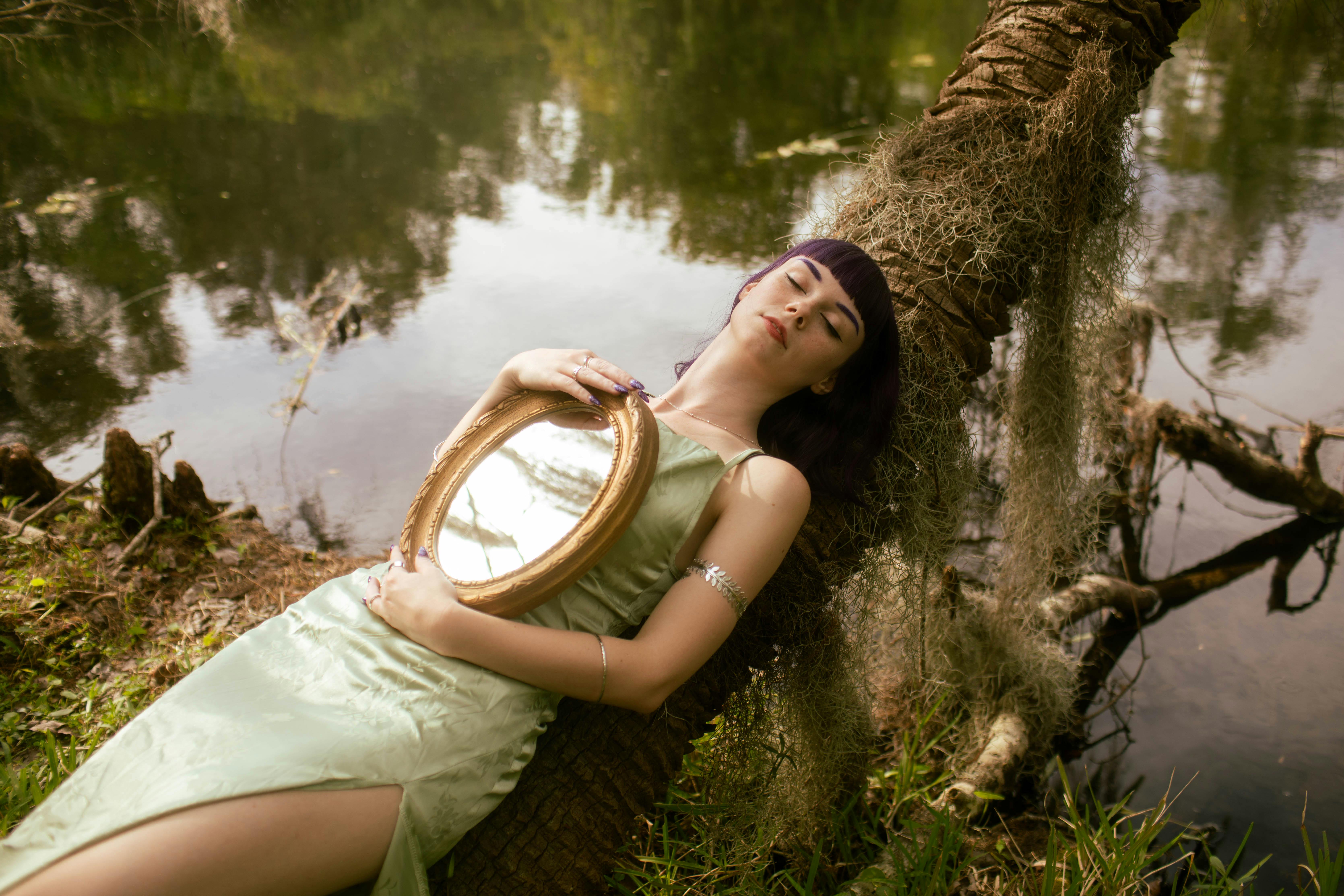 Woman with Mirror Lying Down on Tree · Free Stock Photo