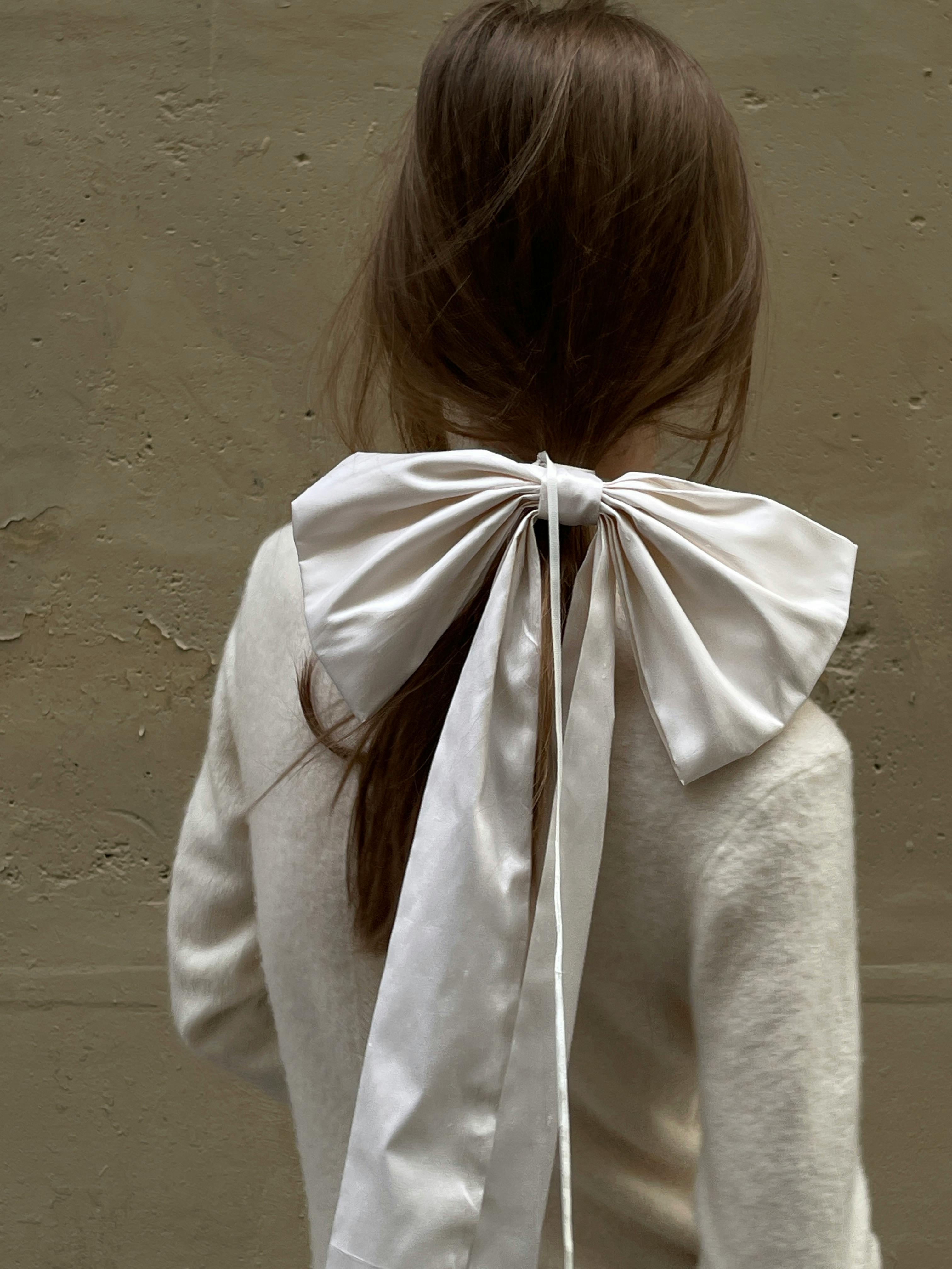 Back View of a Woman Wearing a Long Bow · Free Stock Photo