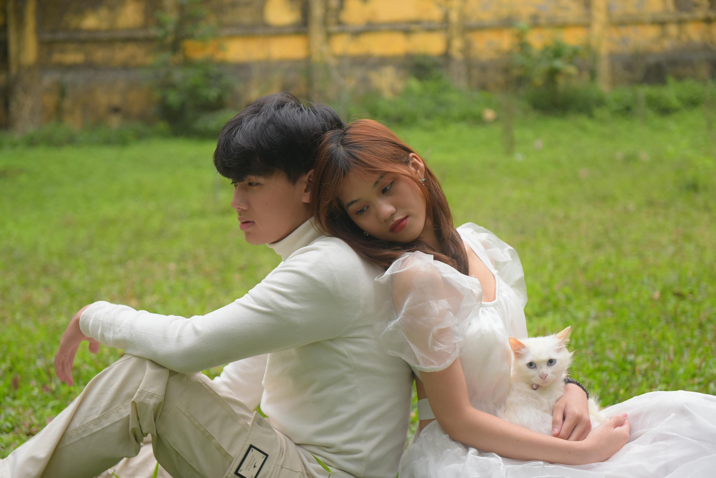 Young Woman with a White Cat on Her Lap Leaning Against Her Boyfriends ...