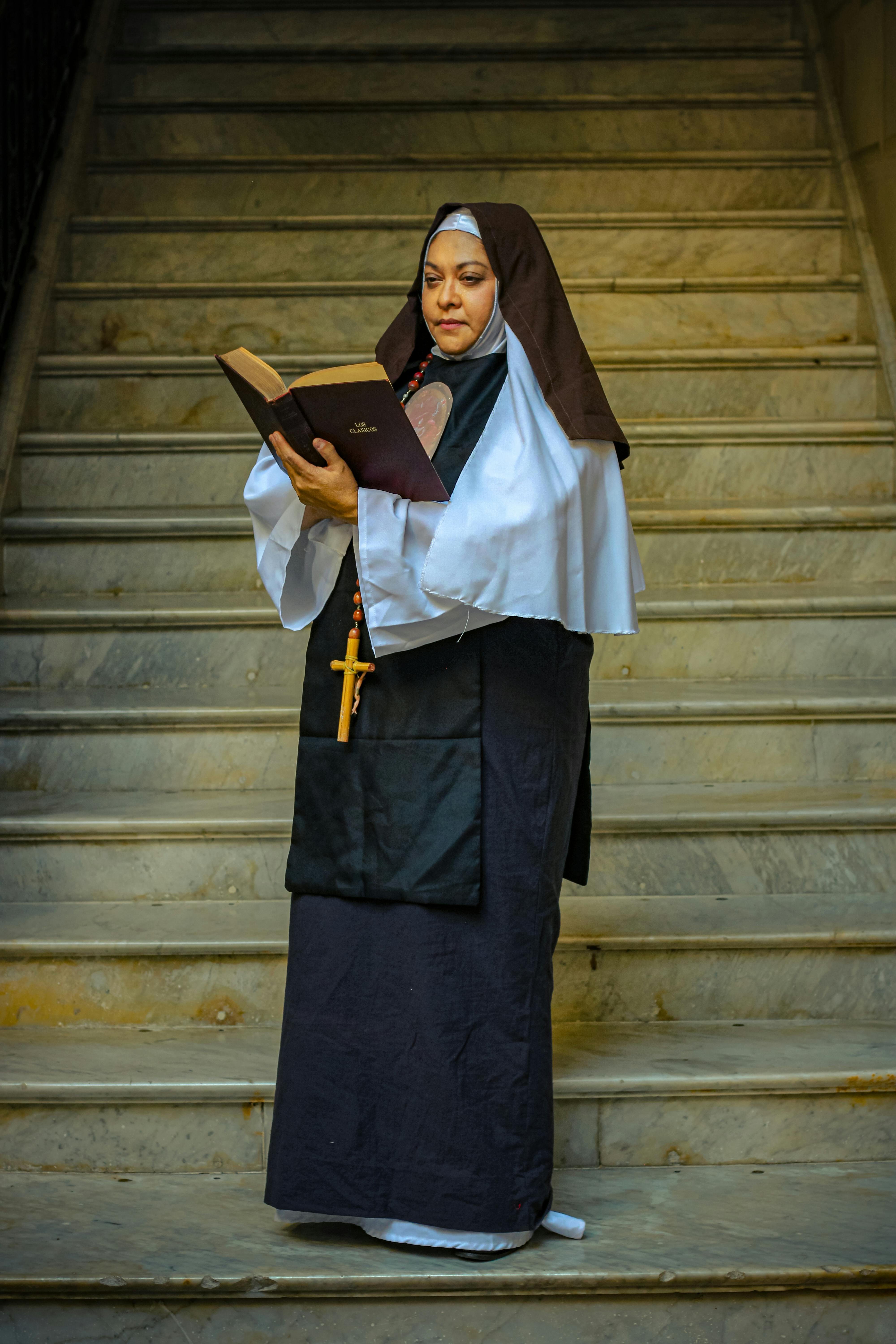 Nun Reading Holy Bible on Stairs · Free Stock Photo