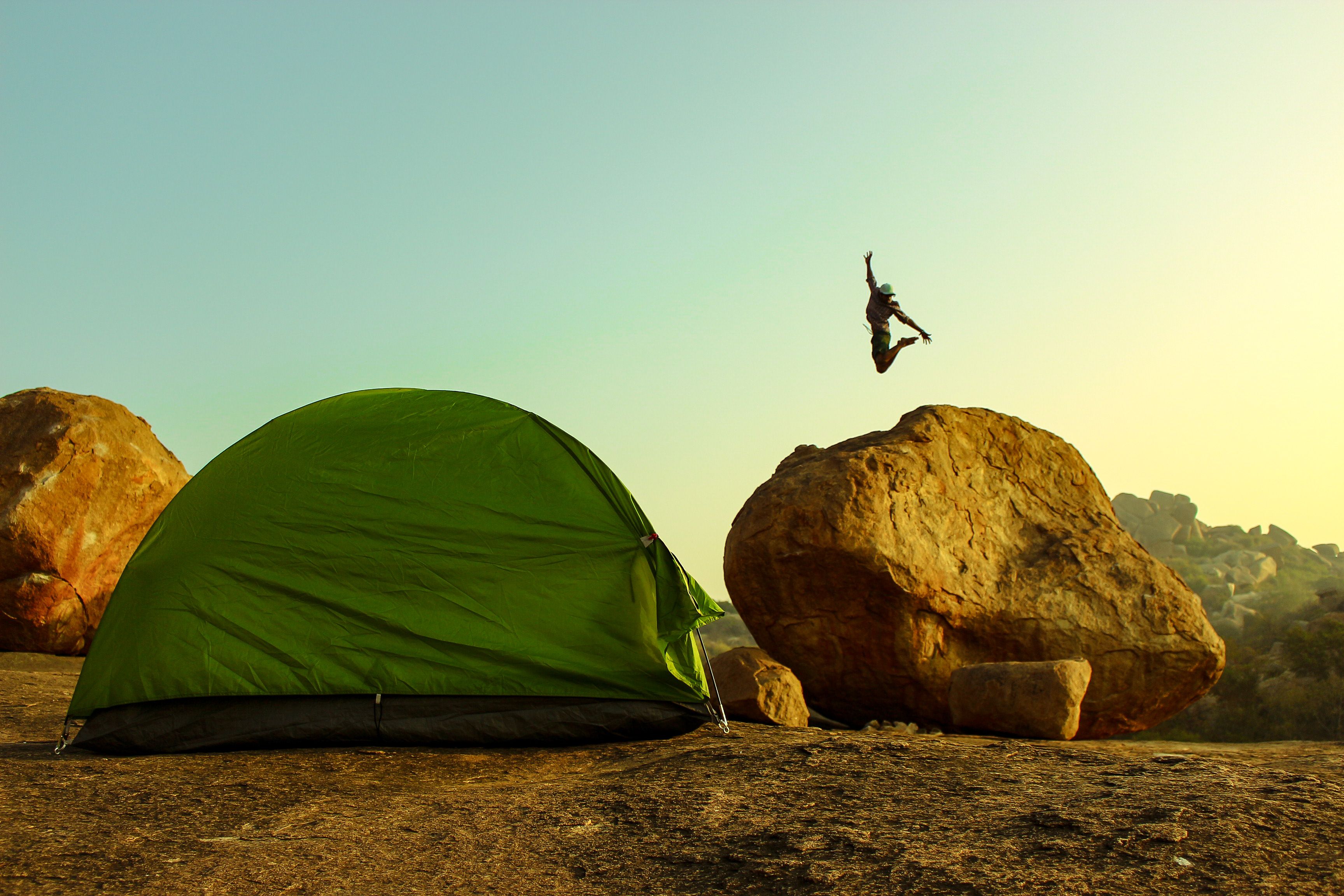 Man Jumping over a Huge Rock at a Campsite · Free Stock Photo