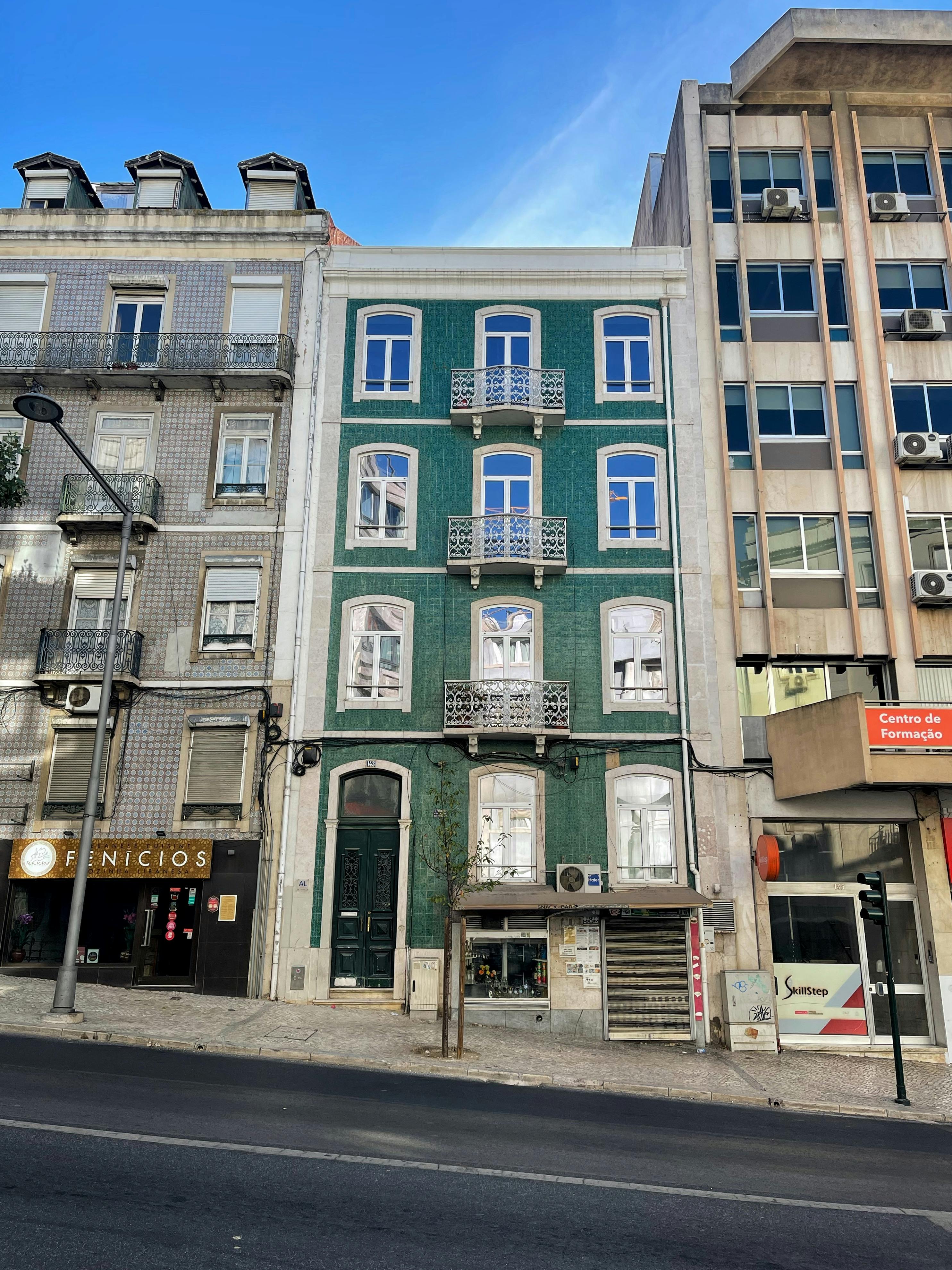 A building with green and blue windows on the side · Free Stock Photo