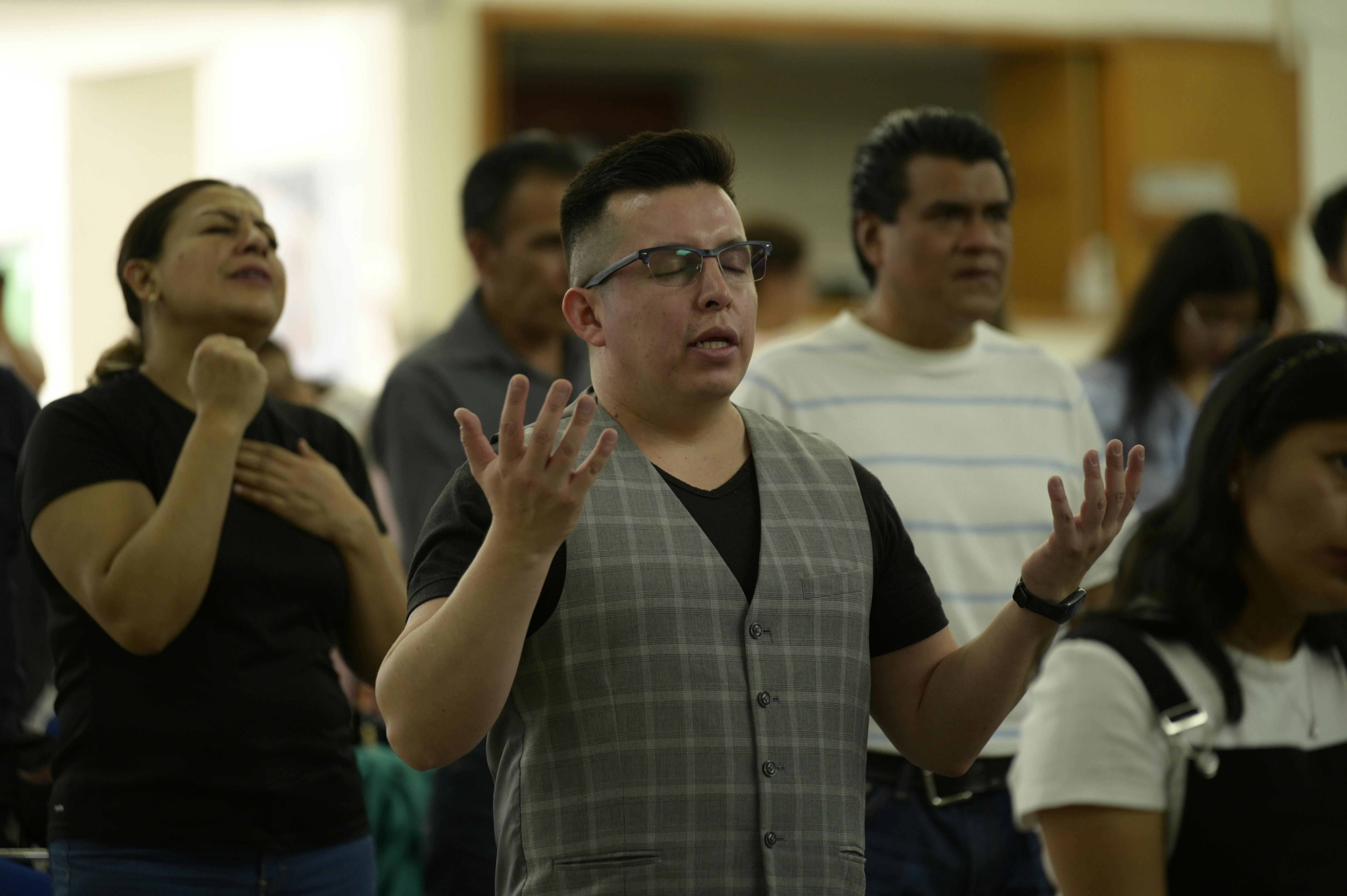 Man Standing and Praying among People at Event · Free Stock Photo